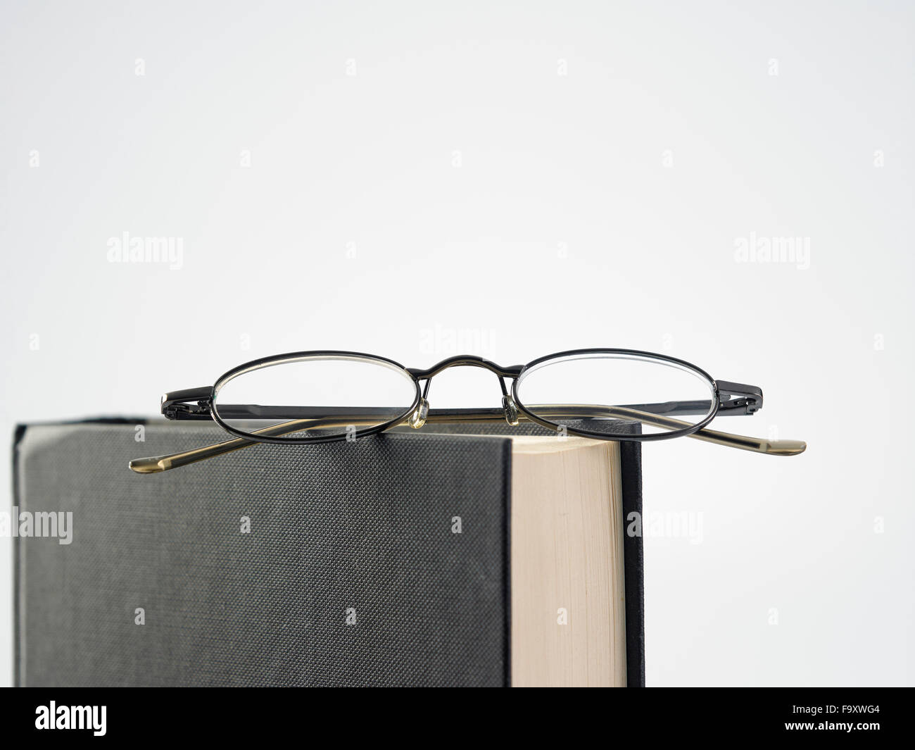 pair of reading glasses rest on top of book Stock Photo - Alamy