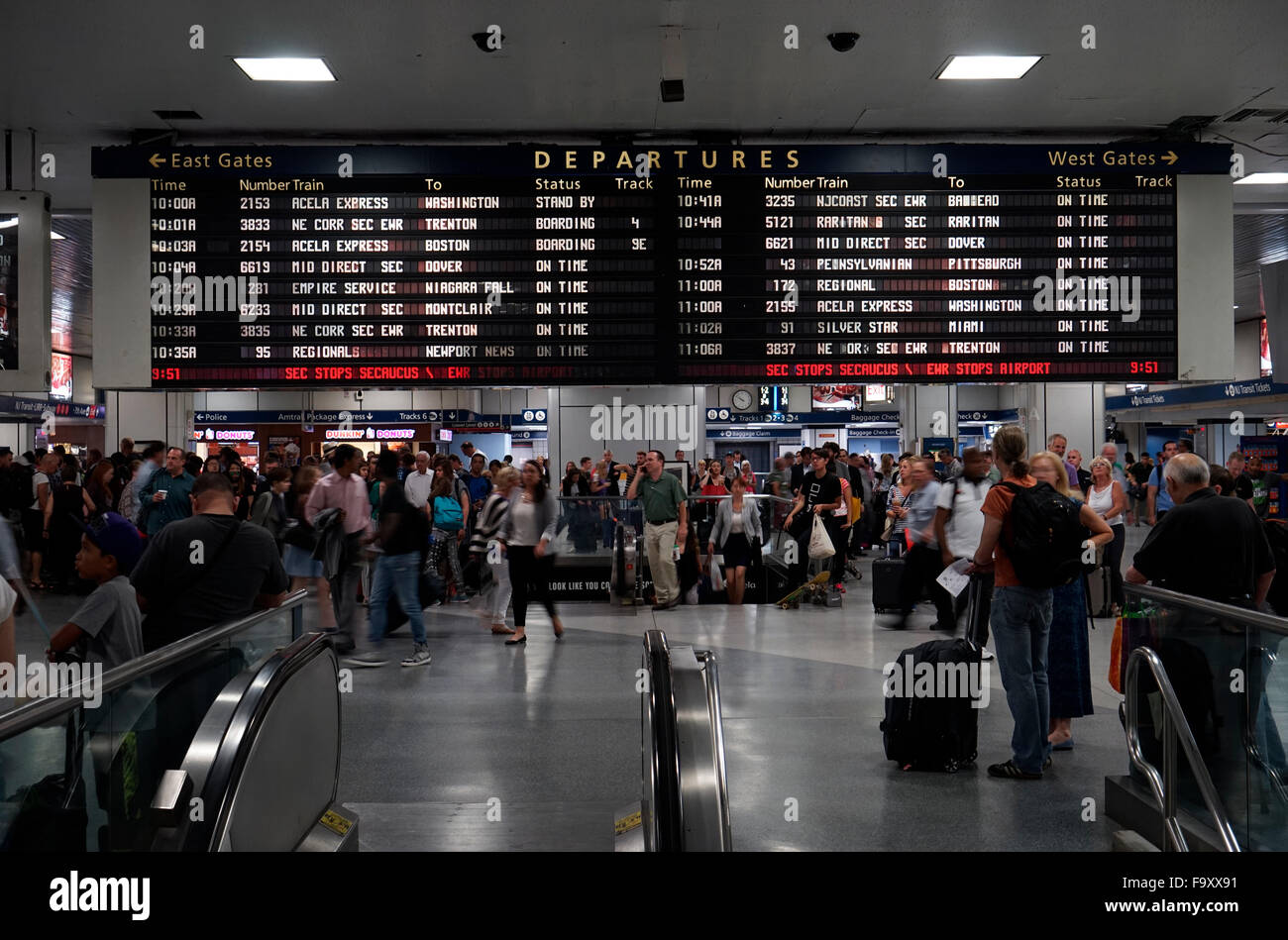 People inside of Penn Station with departure information screen in ...