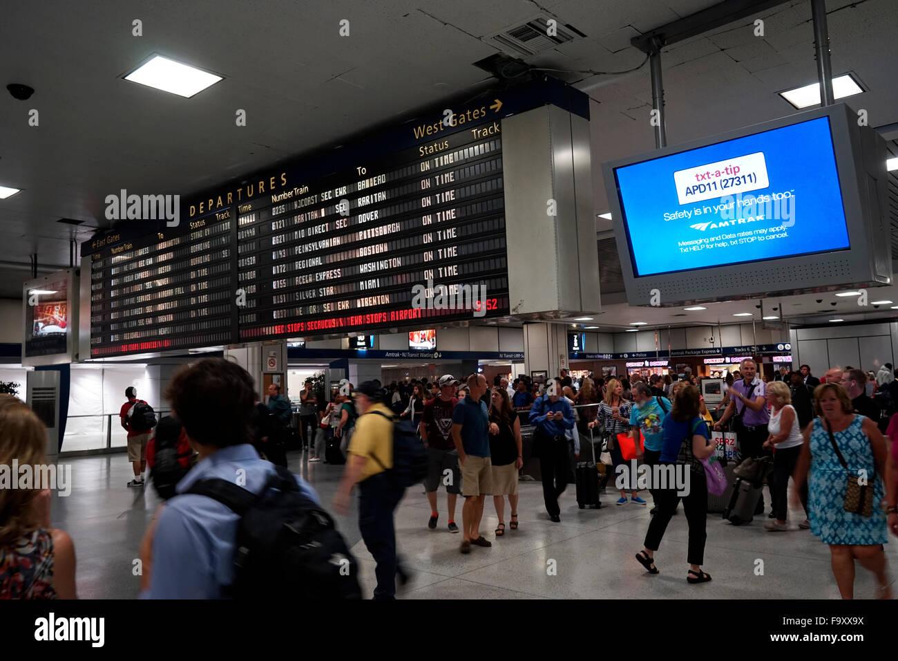 People inside of Penn Station with departure information screen in ...