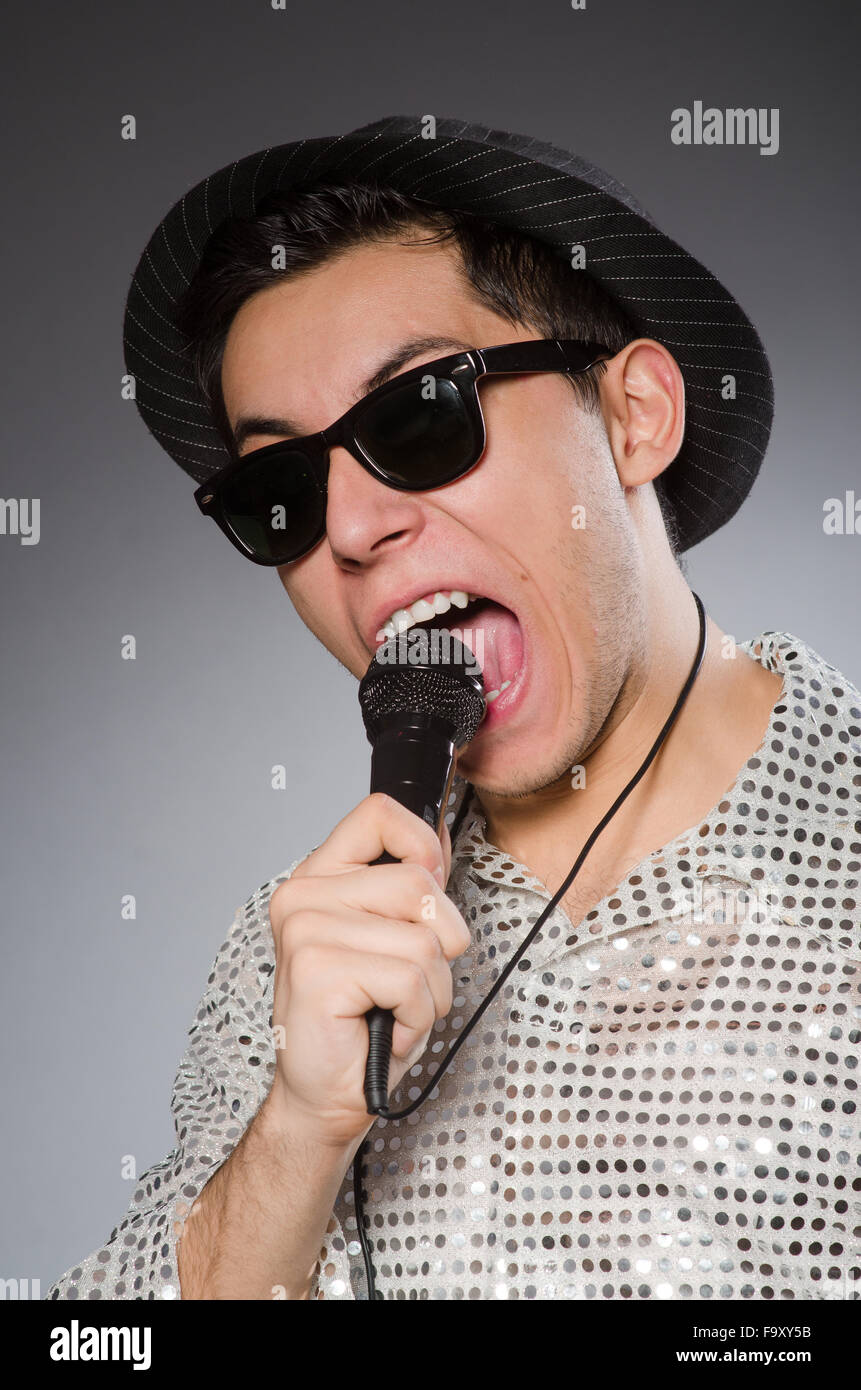 Young cheerful singer with microphone Stock Photo - Alamy