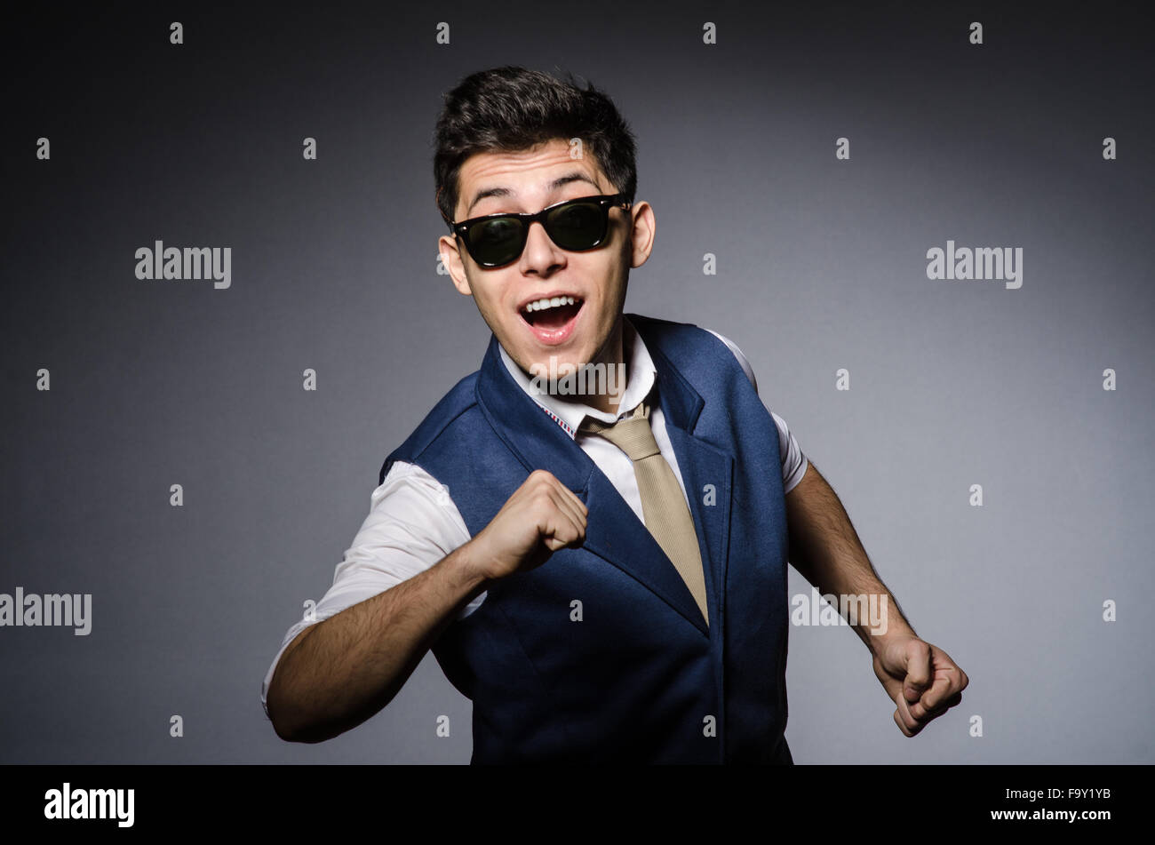 Young man in blue vest against gray Stock Photo - Alamy