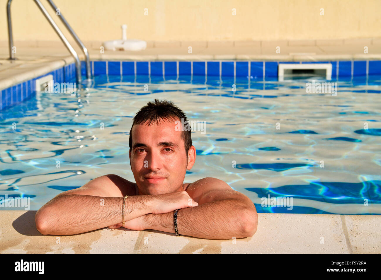 Young Man Hanging on Swimming Pool Edge Relaxing Stock Photo - Alamy