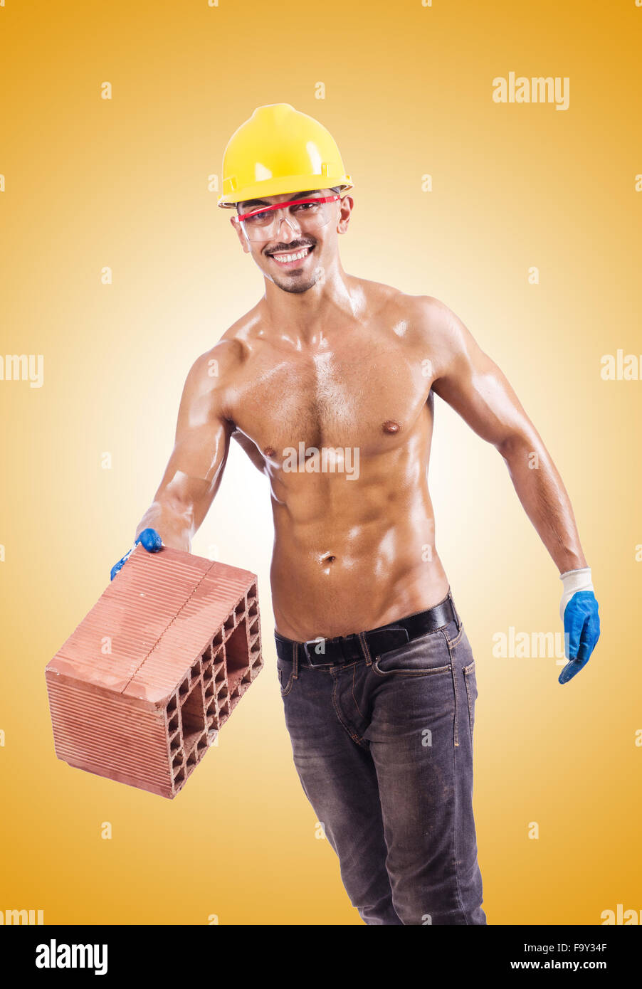 Muscular builder with bricks on white Stock Photo - Alamy