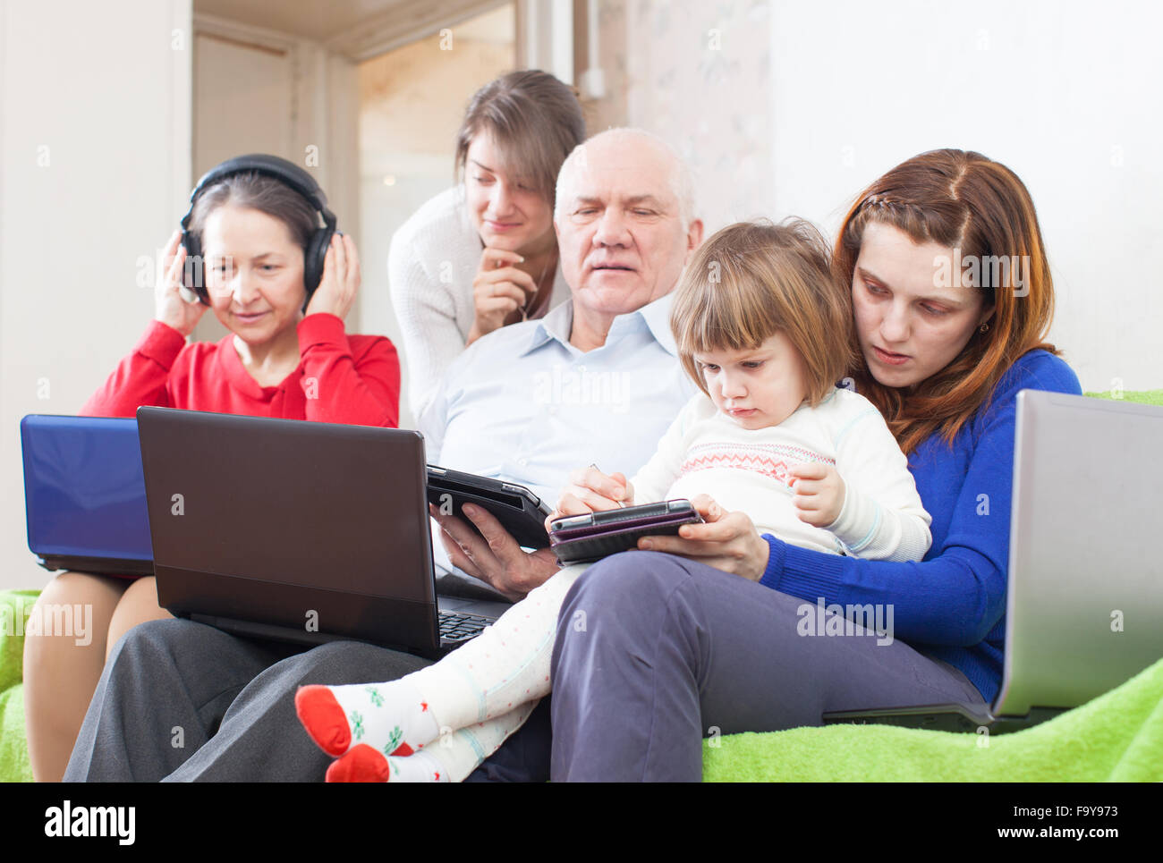 Family uses few various portable computers at home Stock Photo - Alamy