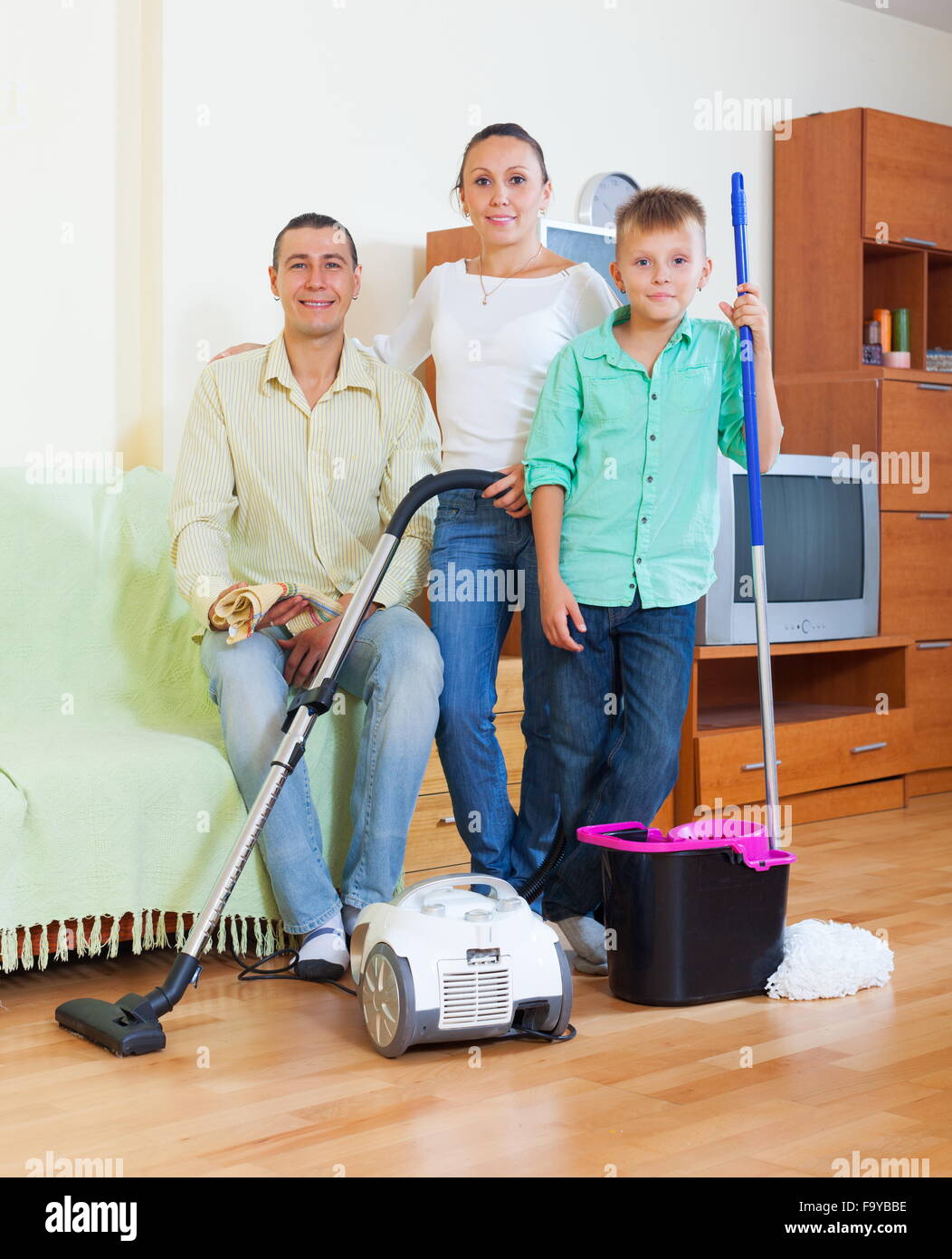 Ordinary family of three finished housework in home Stock Photo - Alamy