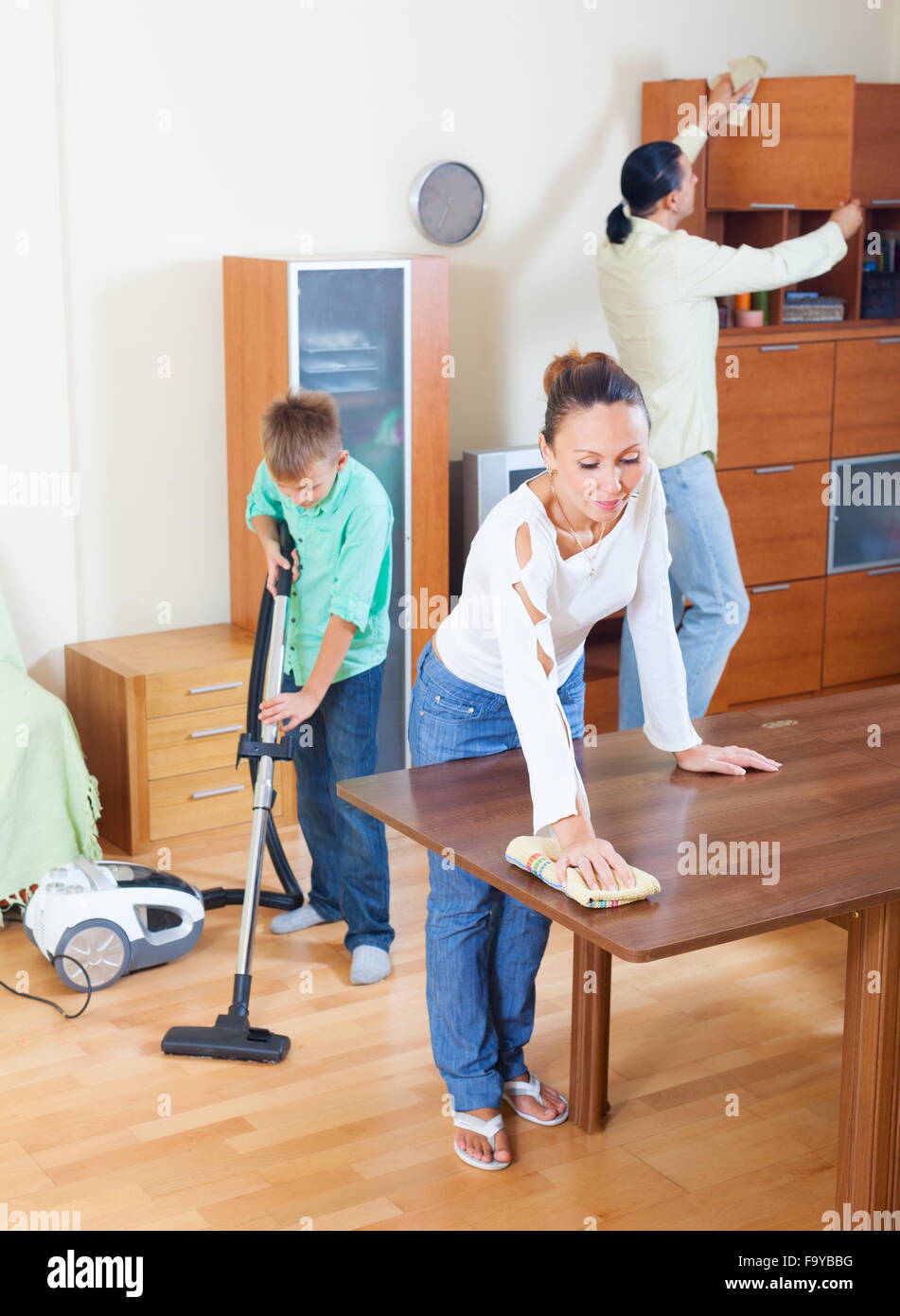 Parents with son dusting together at home Stock Photo - Alamy