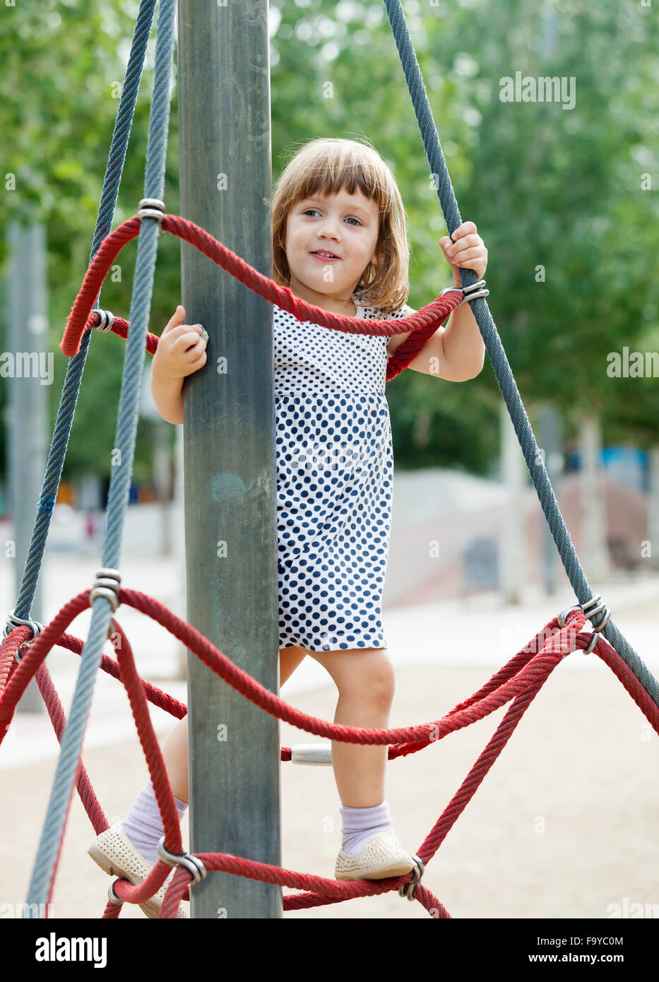 child on ropes at playground area in summer Stock Photo - Alamy
