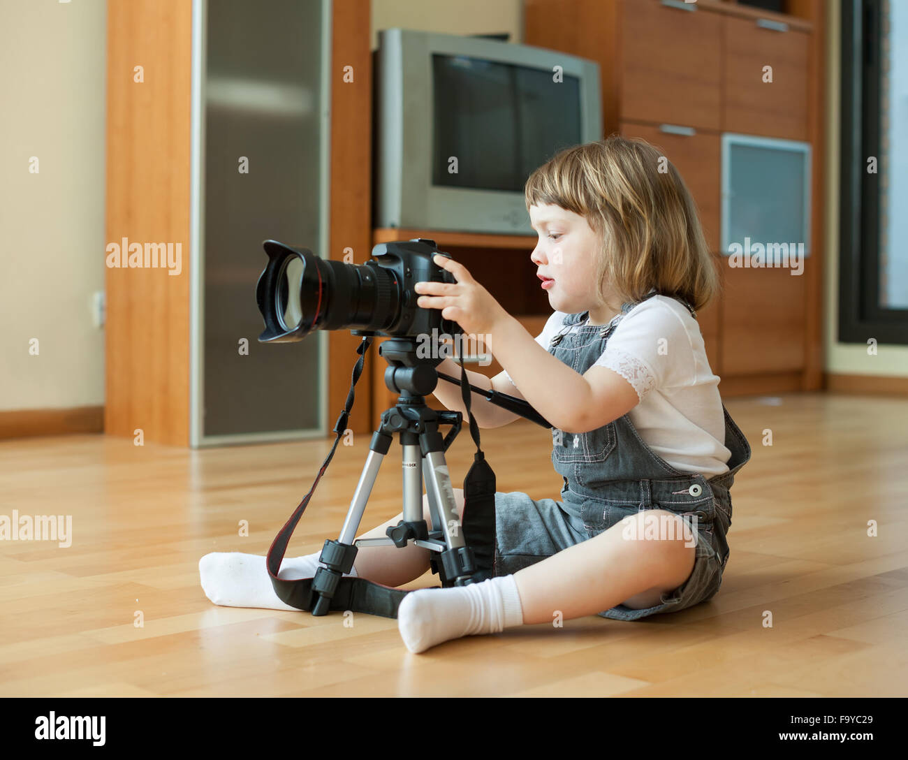 2 years child takes photo with camera and tripod in home Stock Photo ...