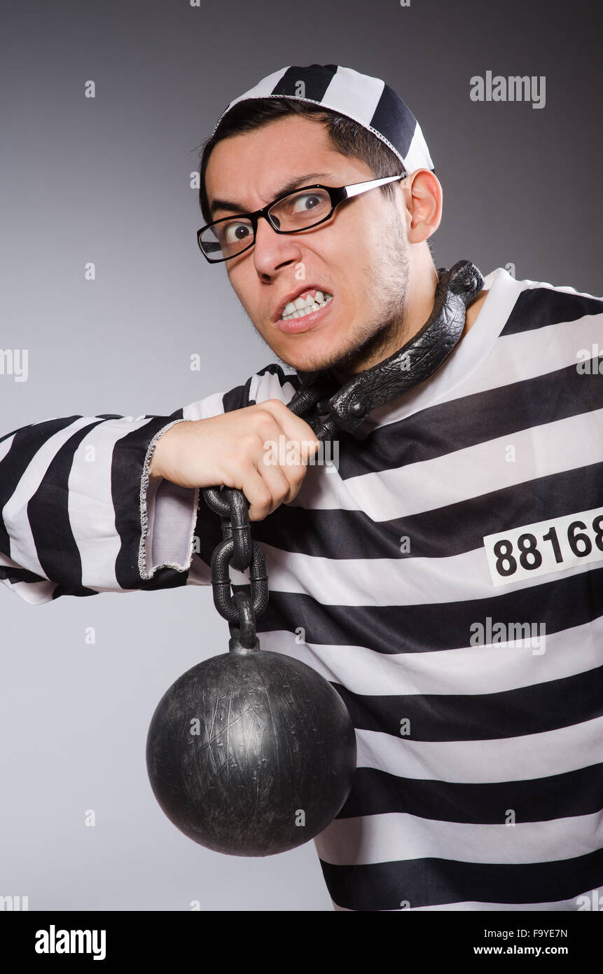 Young prisoner in chains against gray Stock Photo - Alamy