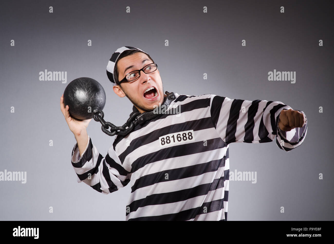 Young prisoner in chains against gray Stock Photo - Alamy