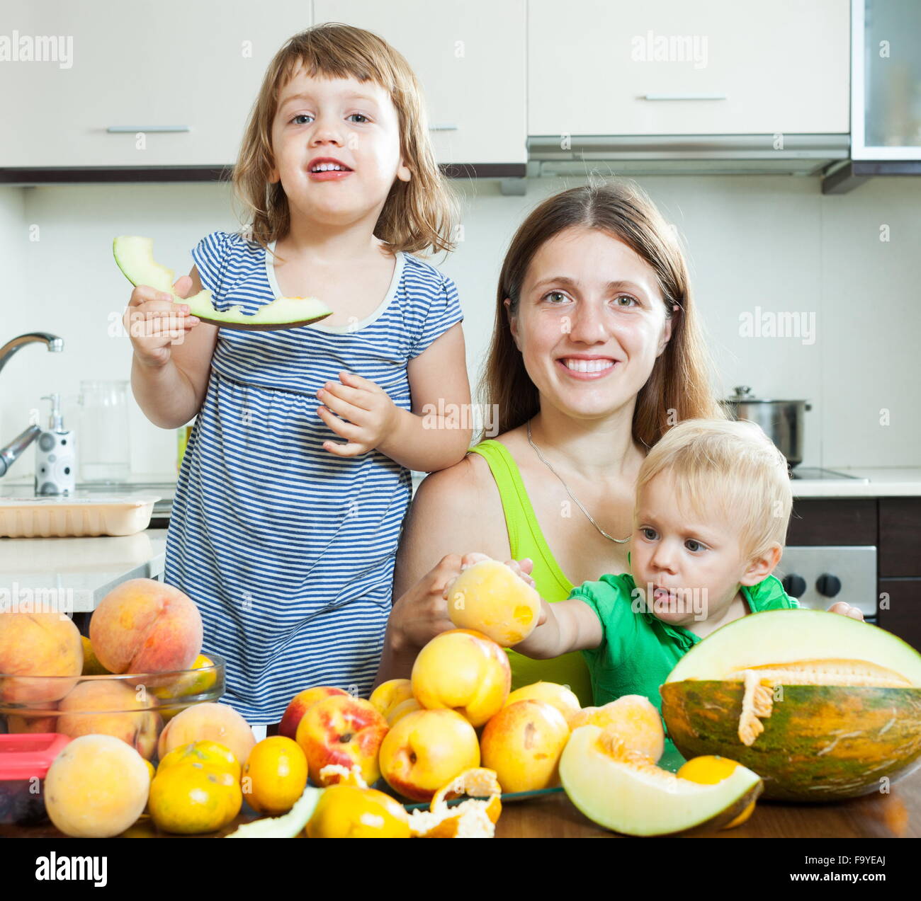 Happy family eating melon and other fruits at home Stock Photo - Alamy