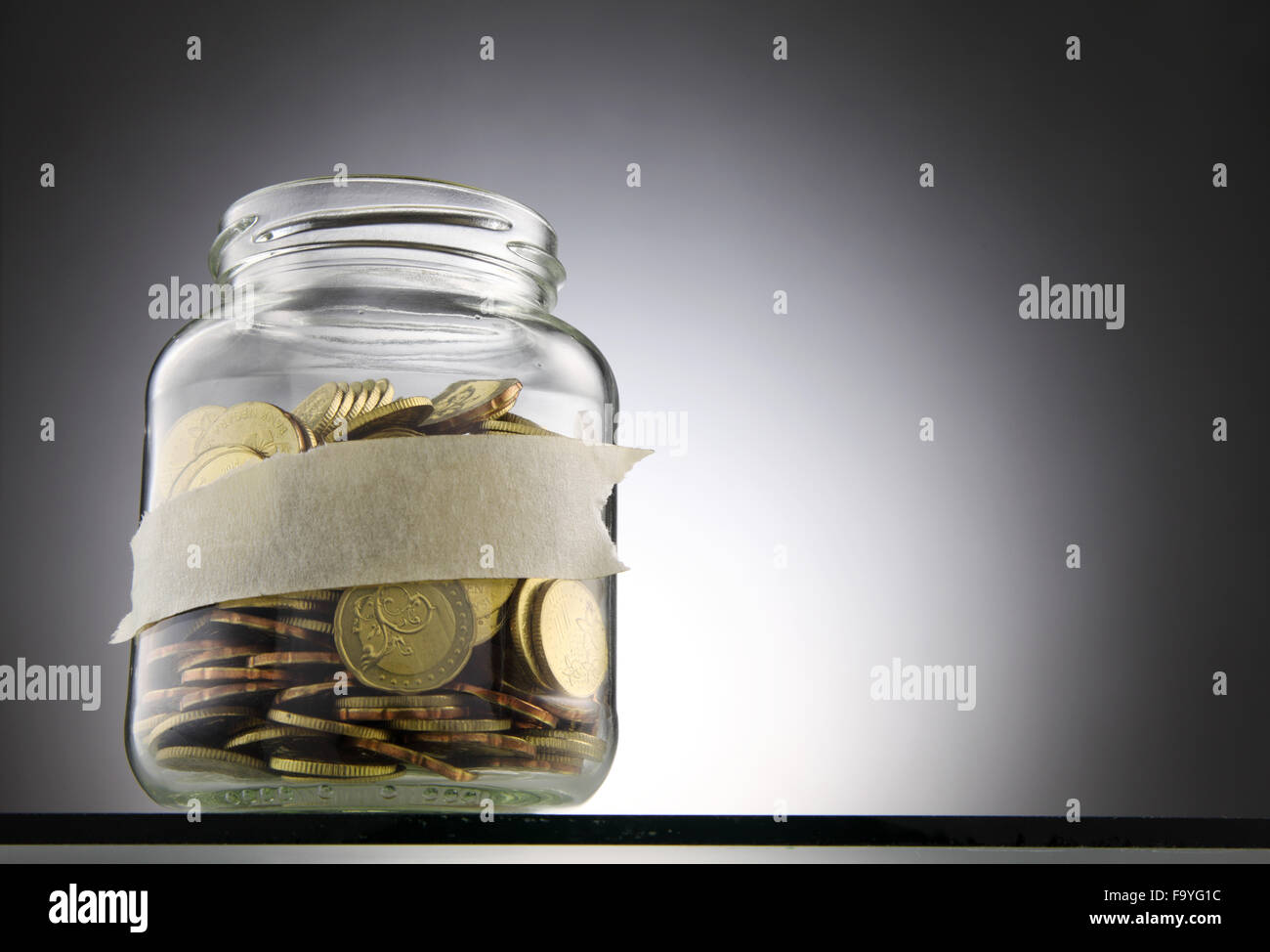 Jar of coins with label for your own text Stock Photo - Alamy