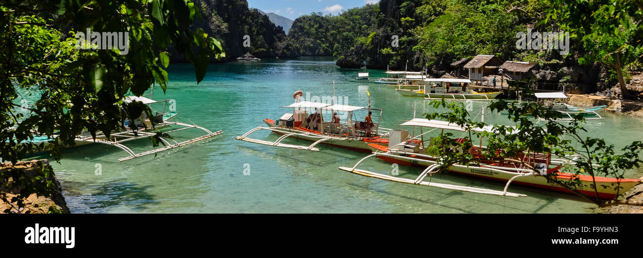 Traditional wooden filipino boats in a blue lagoon at tropical island ...