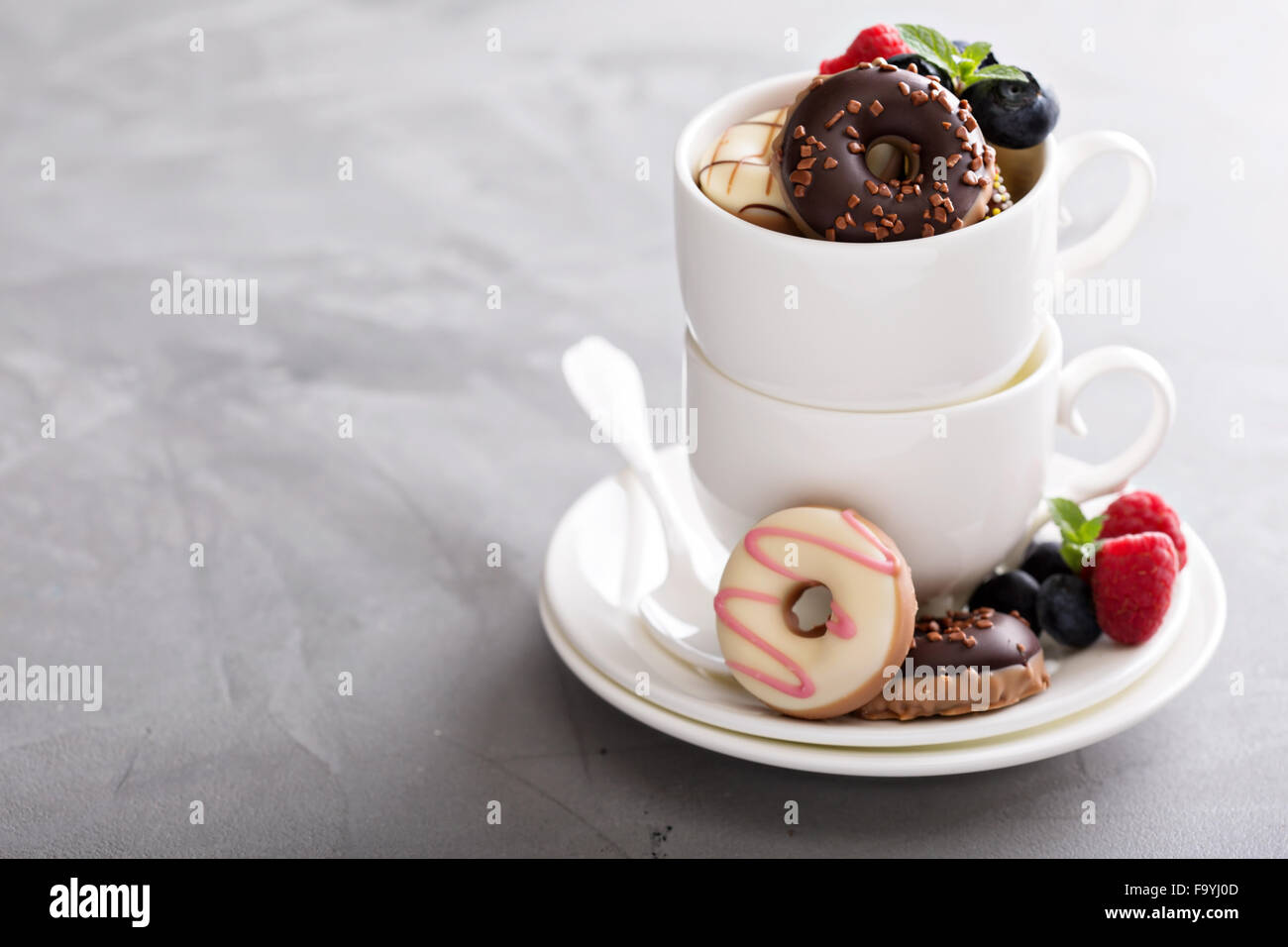 Small glazed mini donuts in stacked coffee cups Stock Photo - Alamy