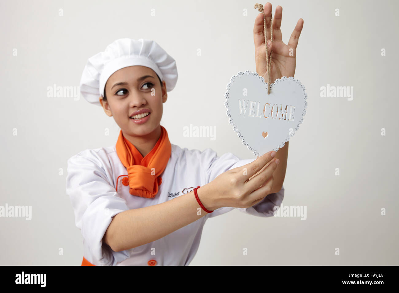 Indian woman with chef uniform holding a welcome signage Stock Photo ...
