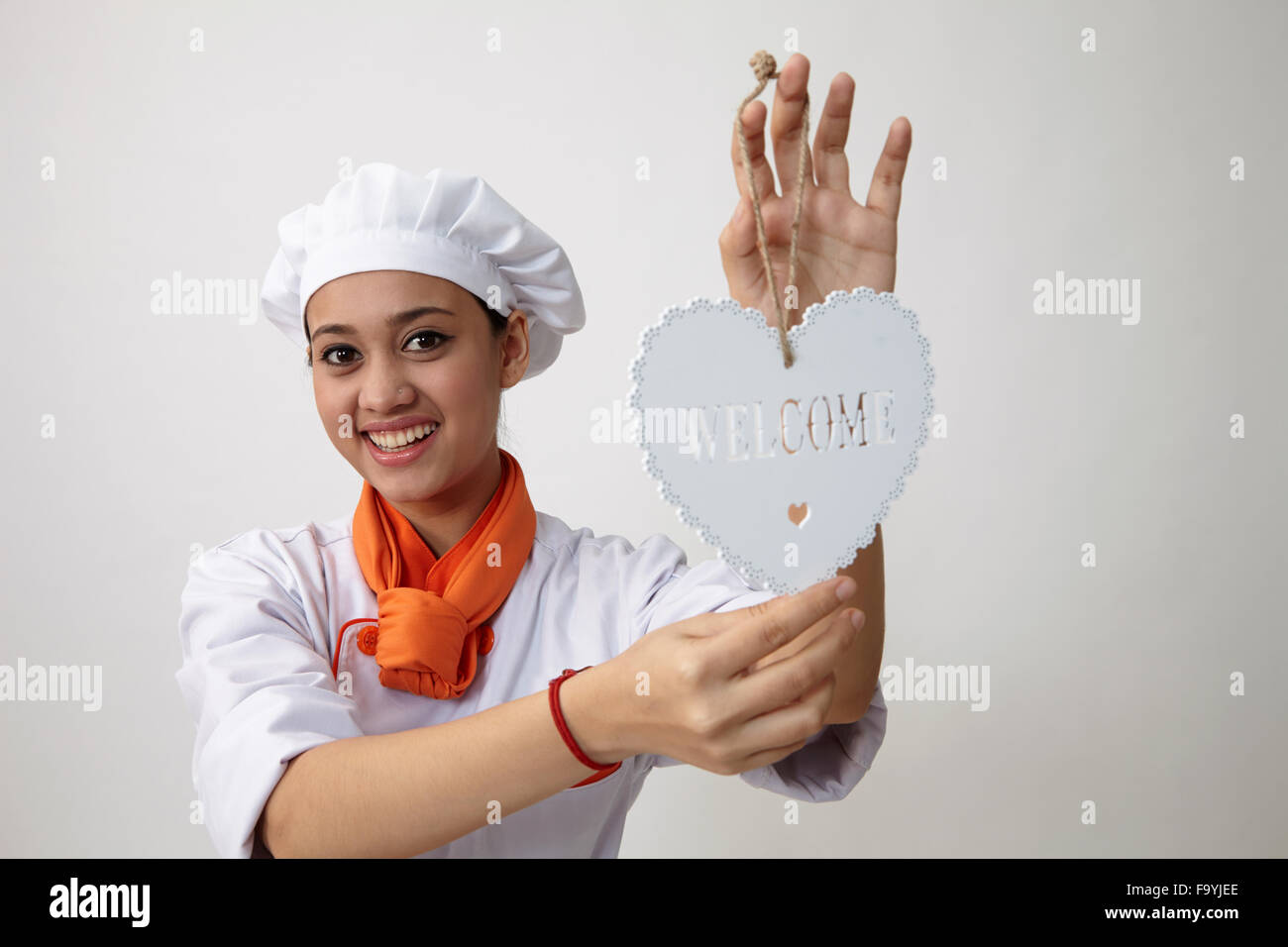 Indian woman with chef uniform holding a welcome signage Stock Photo ...