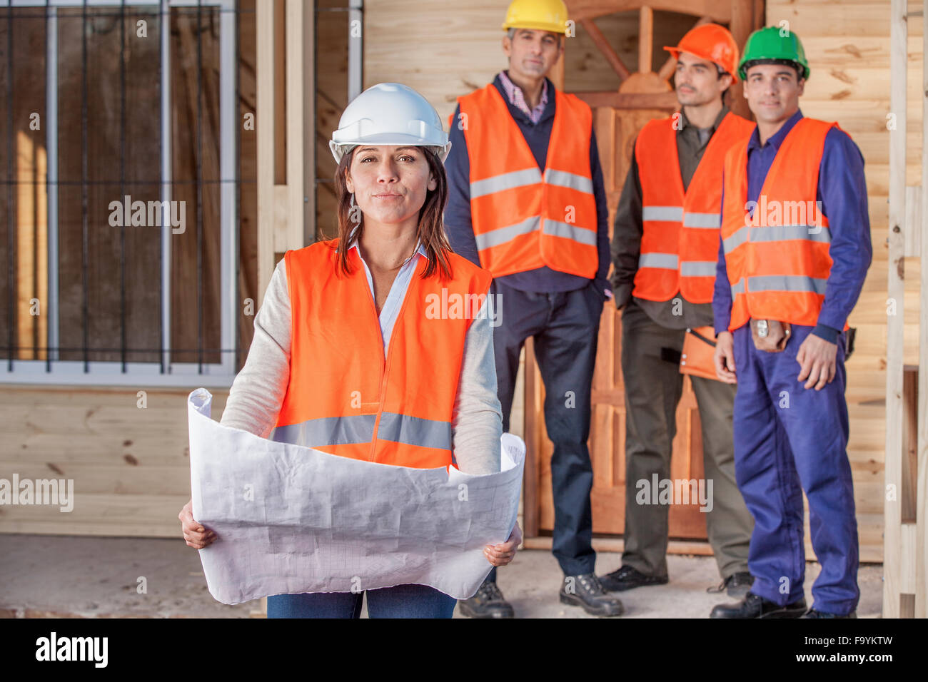 4 person construction crew standing in front of house Stock Photo - Alamy