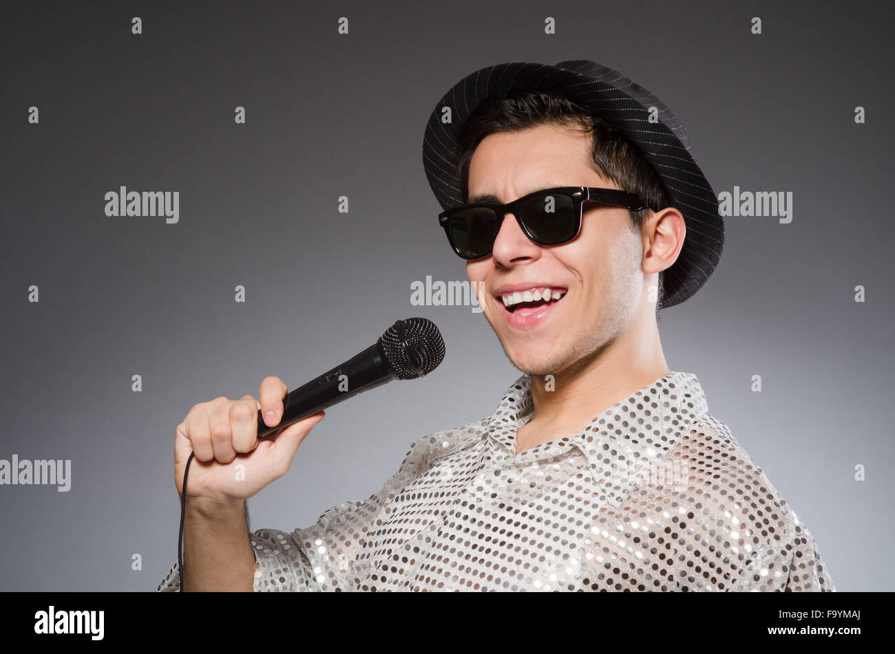 Young cheerful singer with microphone Stock Photo - Alamy