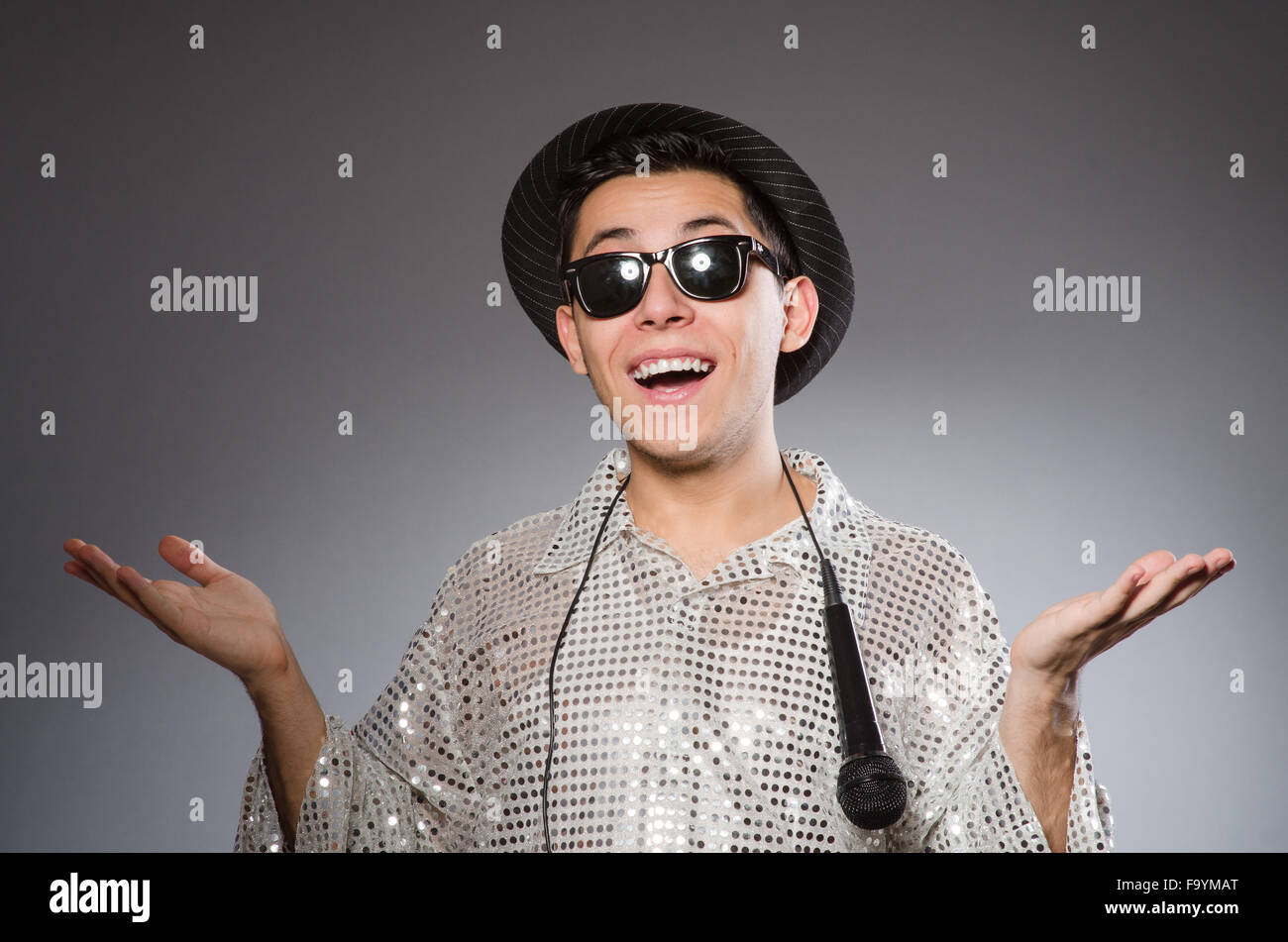 Young cheerful singer with microphone Stock Photo - Alamy