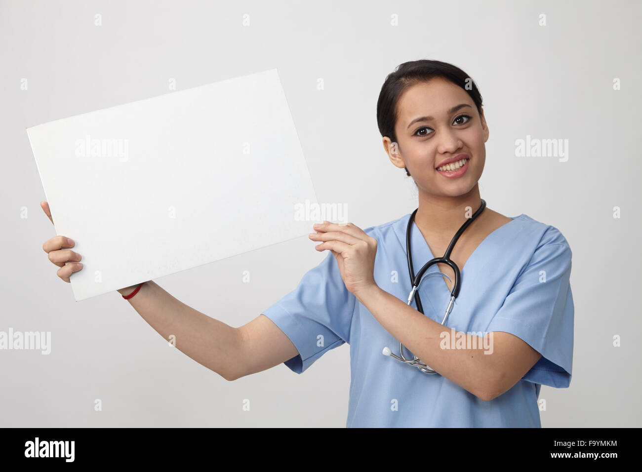 Nurse showing medical sign billboard standing, Young smiling woman ...