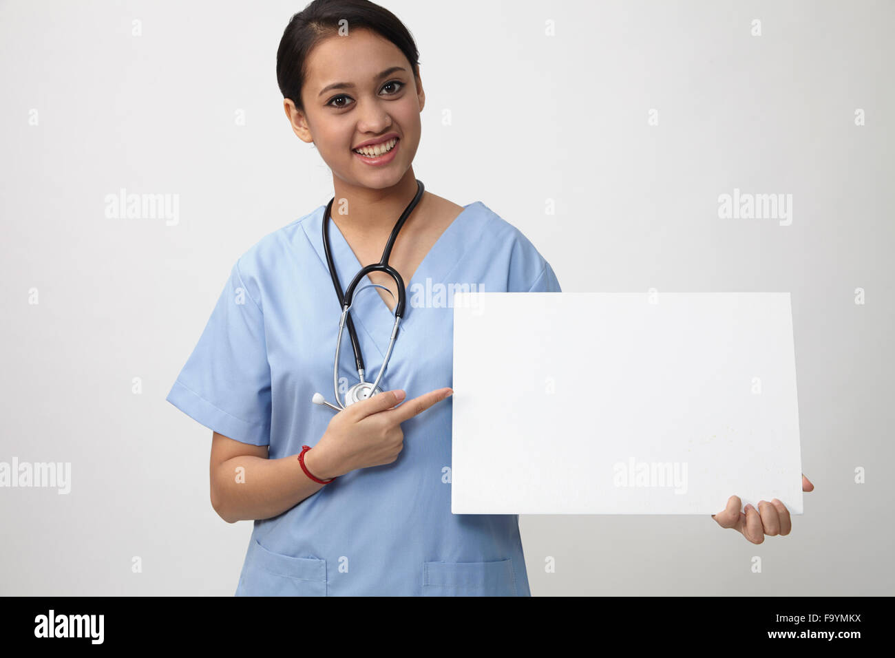 Nurse showing medical sign billboard standing, Young smiling woman ...