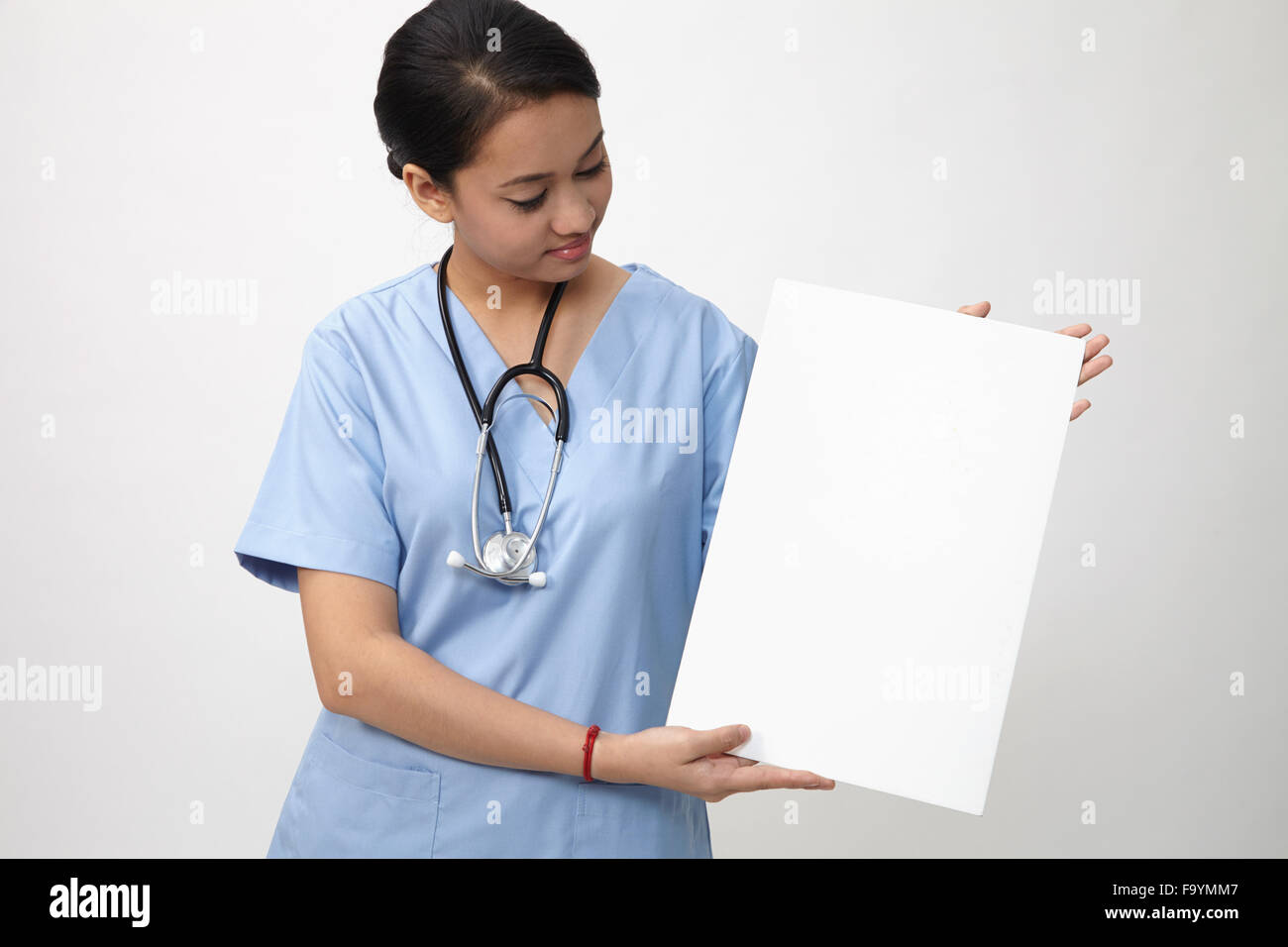 Nurse showing medical sign billboard standing, Young smiling woman ...