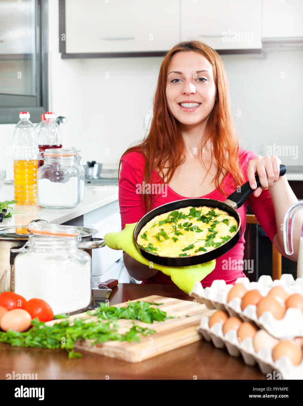 Joyful woman in red with cooked omelet in home kitchen Stock Photo - Alamy
