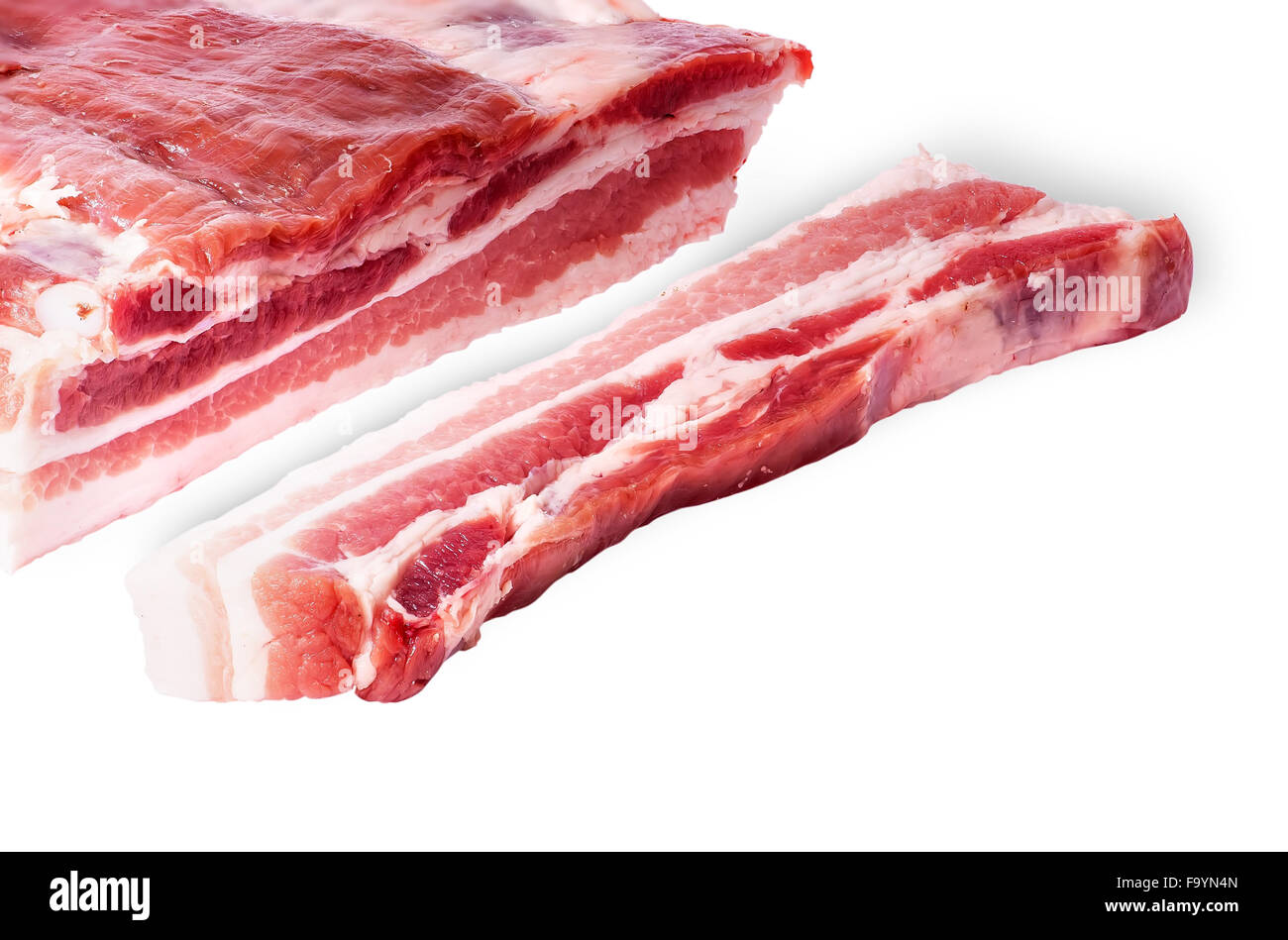 Cut a piece of bacon next to a large isolated on white background Stock ...