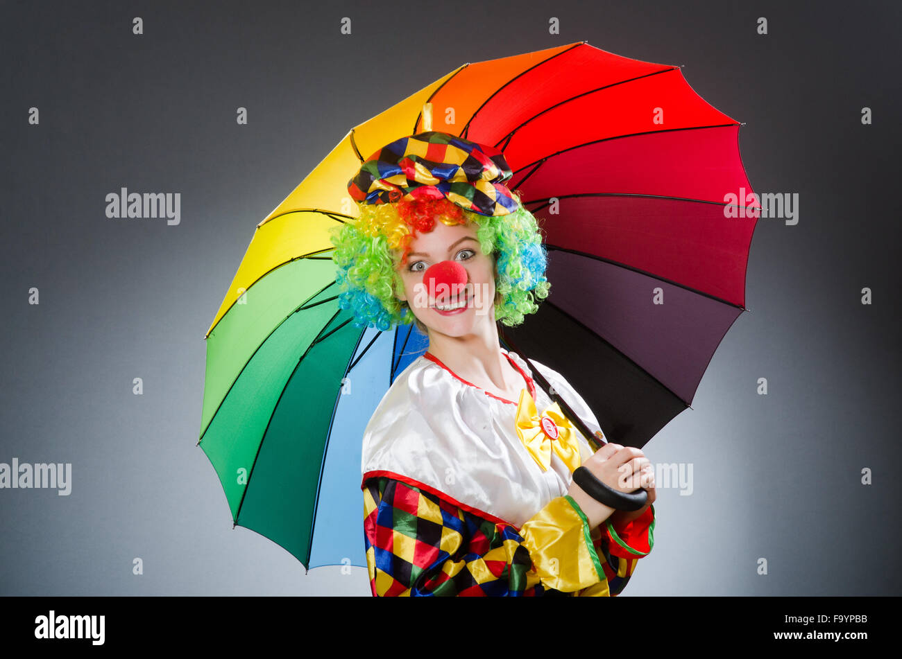 Clown with umbrella in funny concept Stock Photo - Alamy