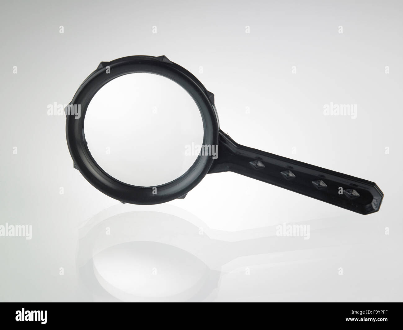 Magnifying glass on top of glass table Stock Photo - Alamy