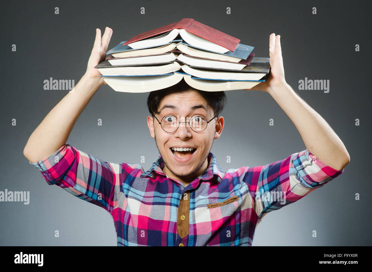 Funny student with many books Stock Photo - Alamy