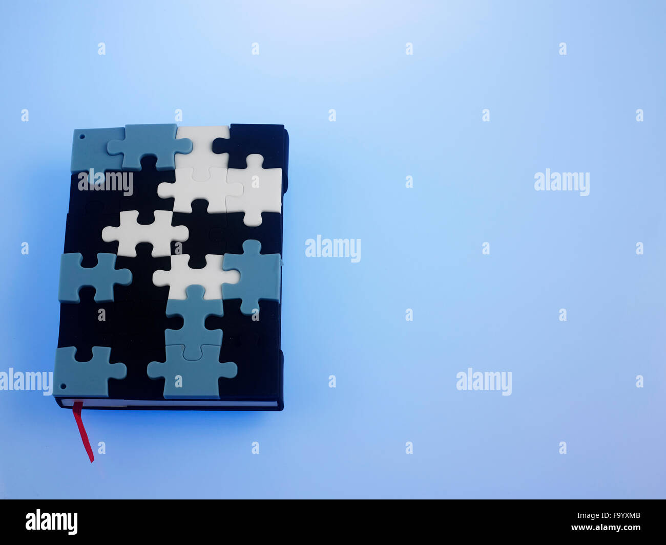 jigsaw puzzle note book on the blue background Stock Photo - Alamy
