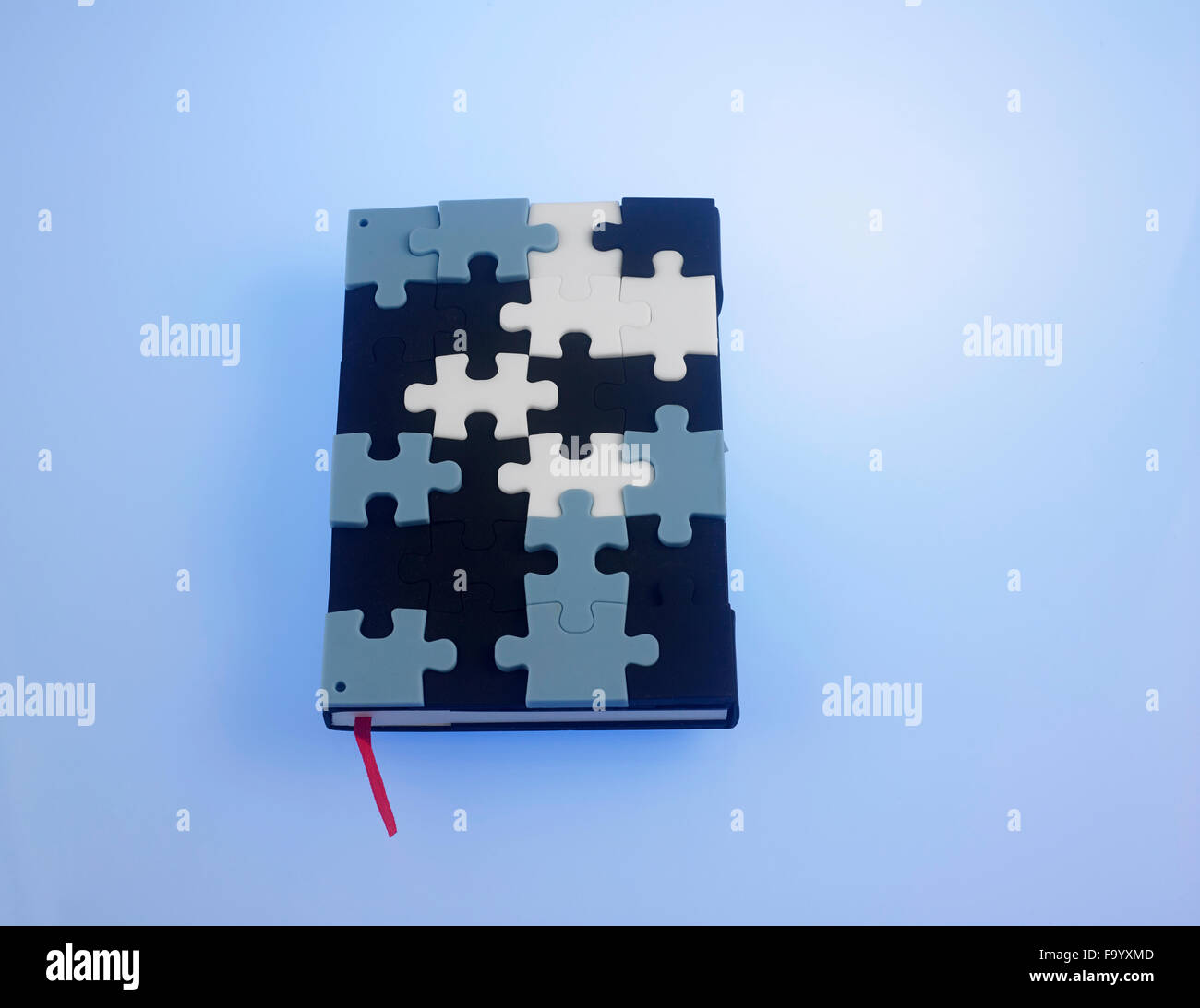 jigsaw puzzle note book on the blue background Stock Photo - Alamy