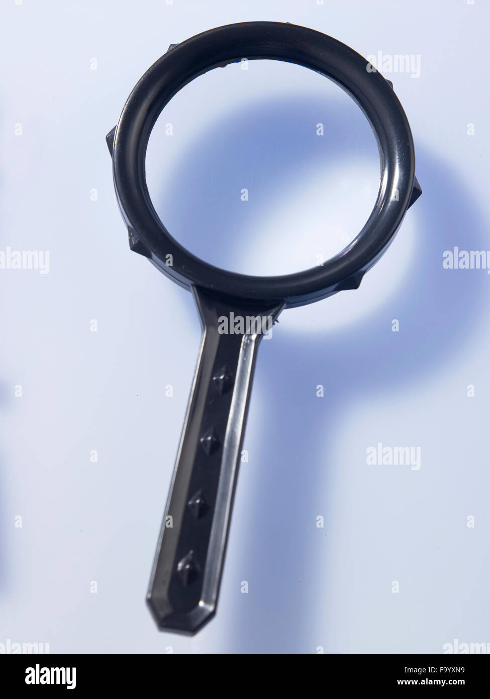 Magnifying glass on top of glass table Stock Photo - Alamy