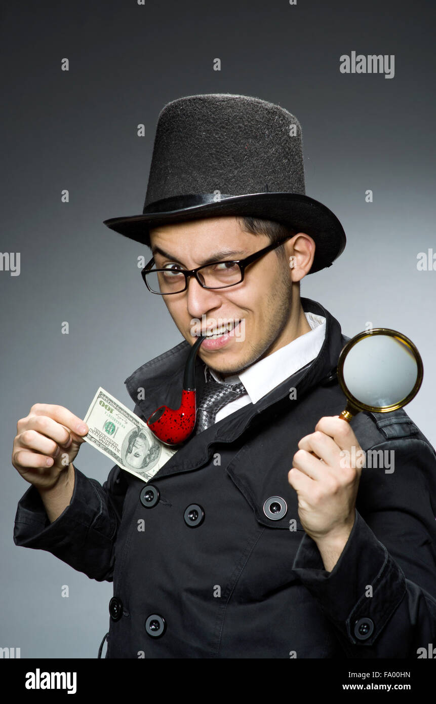 Young detective in black coat with money against gray Stock Photo - Alamy