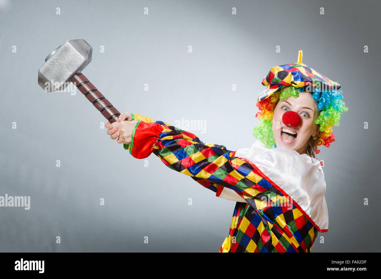 Clown with hammer in funny concept Stock Photo - Alamy