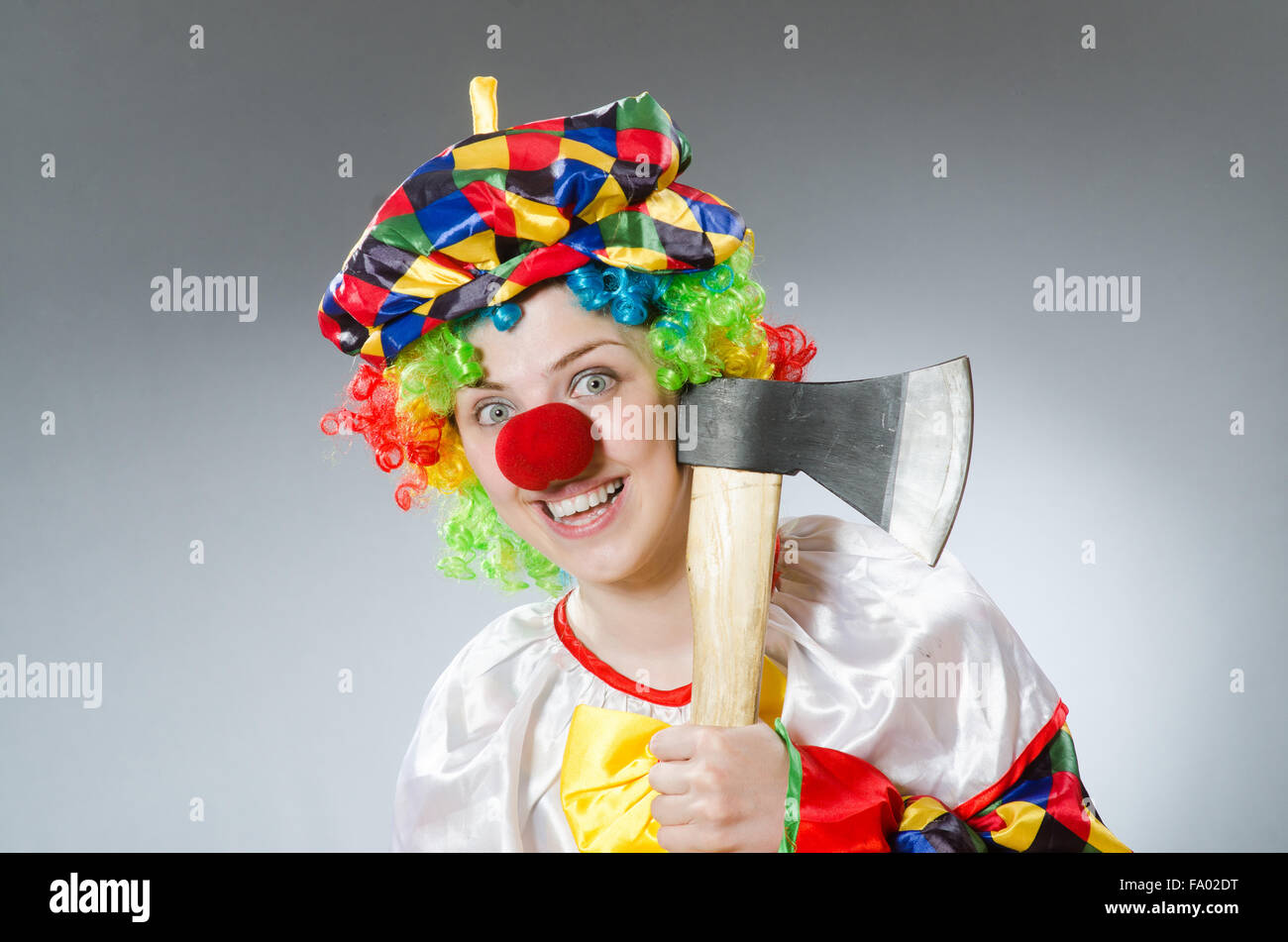 Clown with axe in funny concept Stock Photo - Alamy
