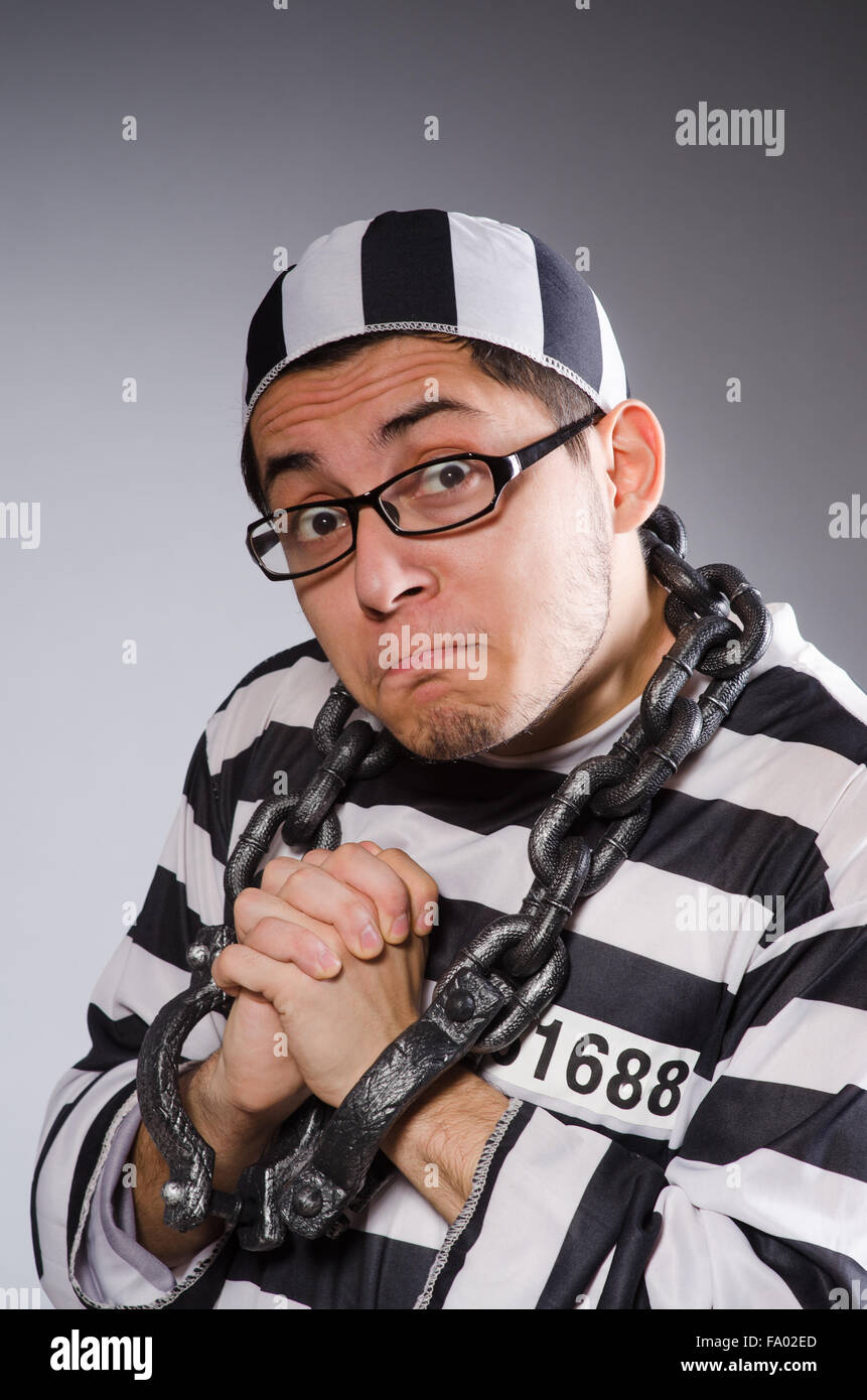Young prisoner in chains against gray Stock Photo - Alamy