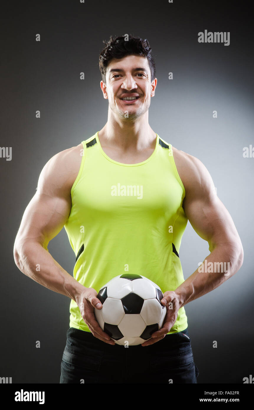 Muscular man with football ball Stock Photo - Alamy