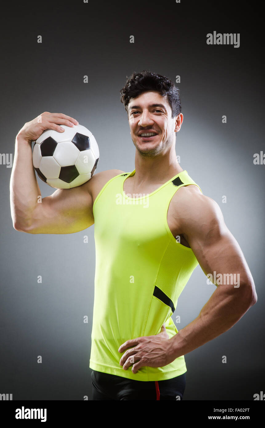 Muscular man with football ball Stock Photo - Alamy