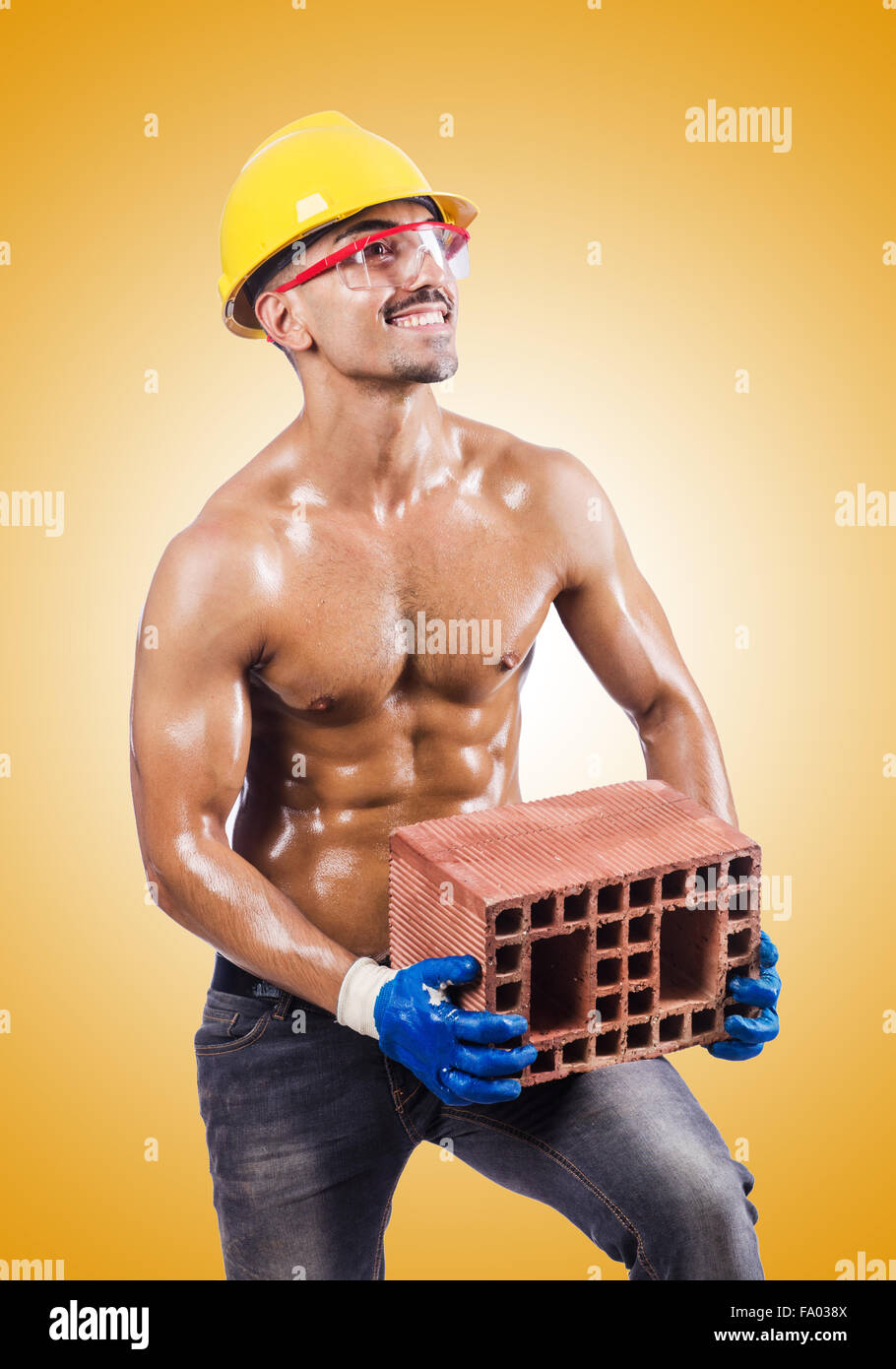 Muscular builder with bricks on white Stock Photo - Alamy