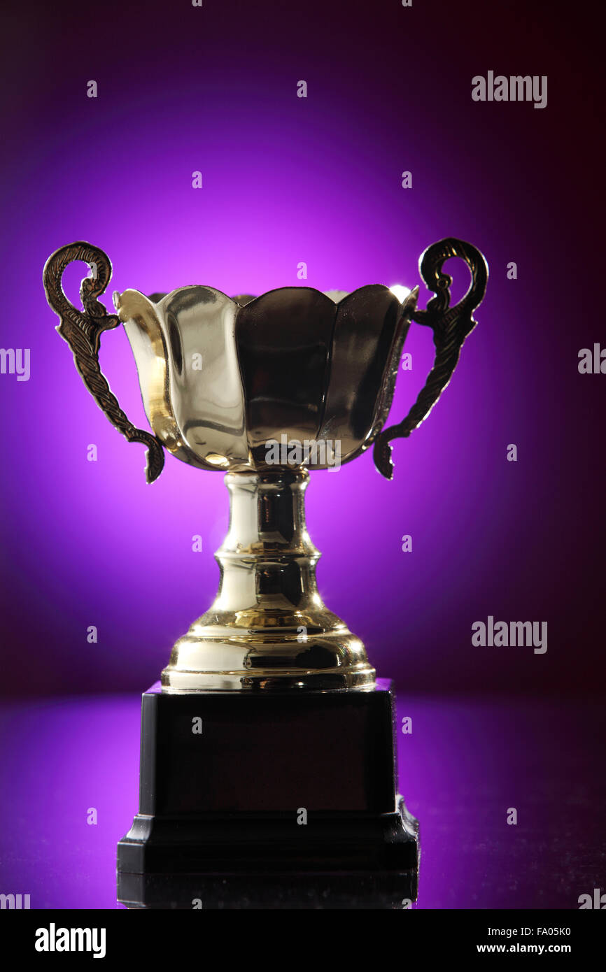 golden trophy on the purple background Stock Photo - Alamy