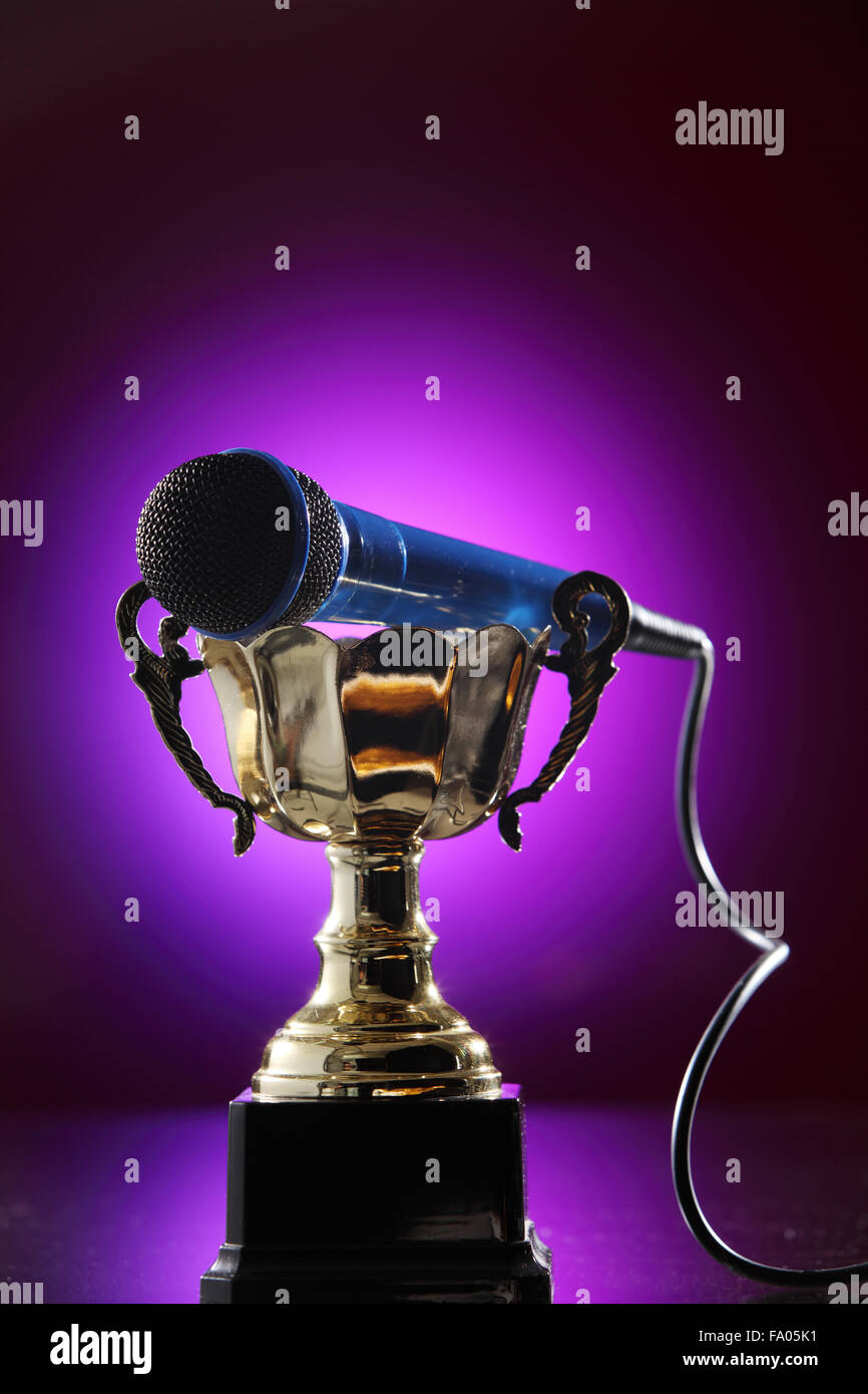 golden trophy and microphone with purple background Stock Photo - Alamy