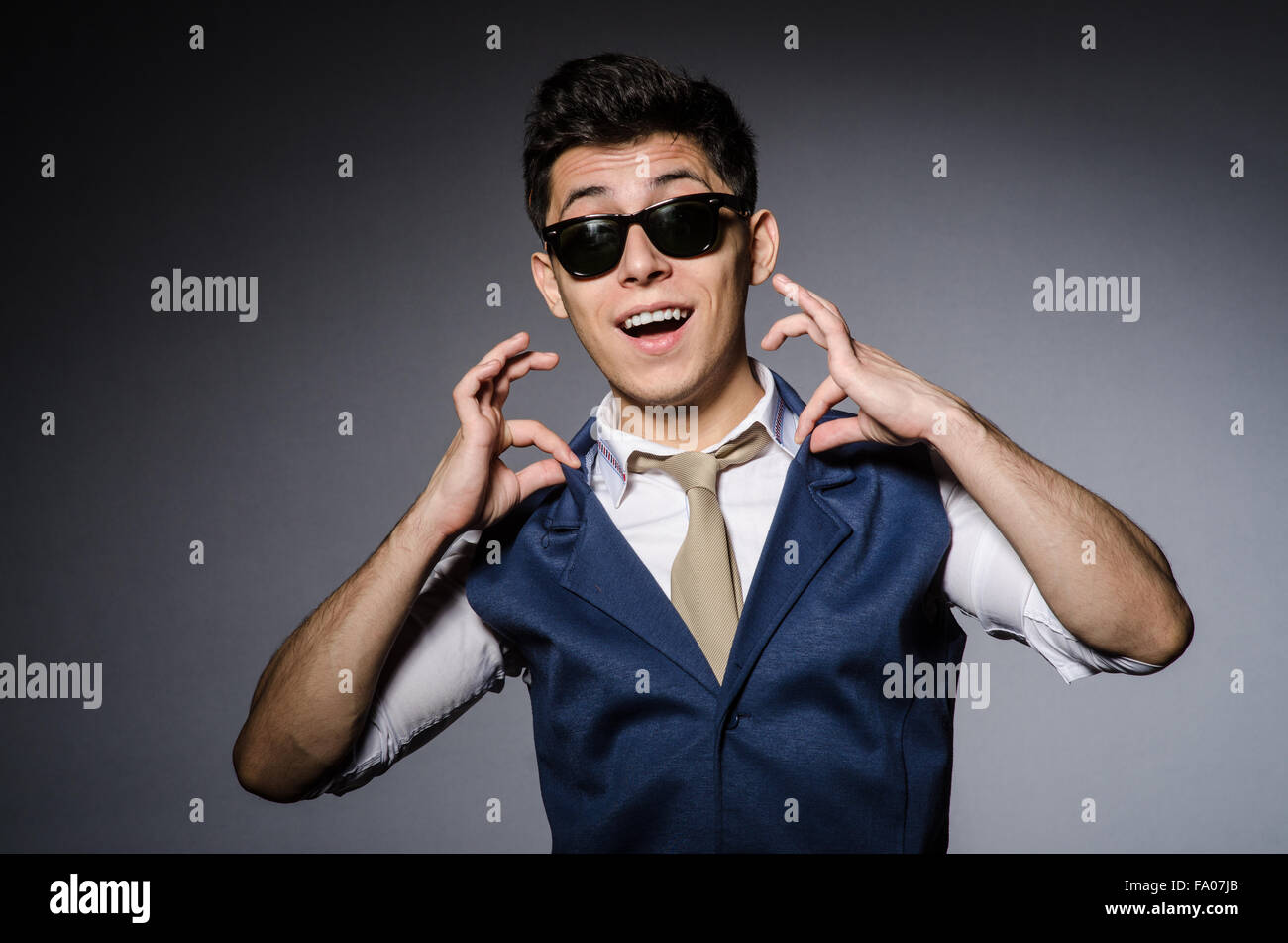 Young man in blue vest against gray Stock Photo - Alamy