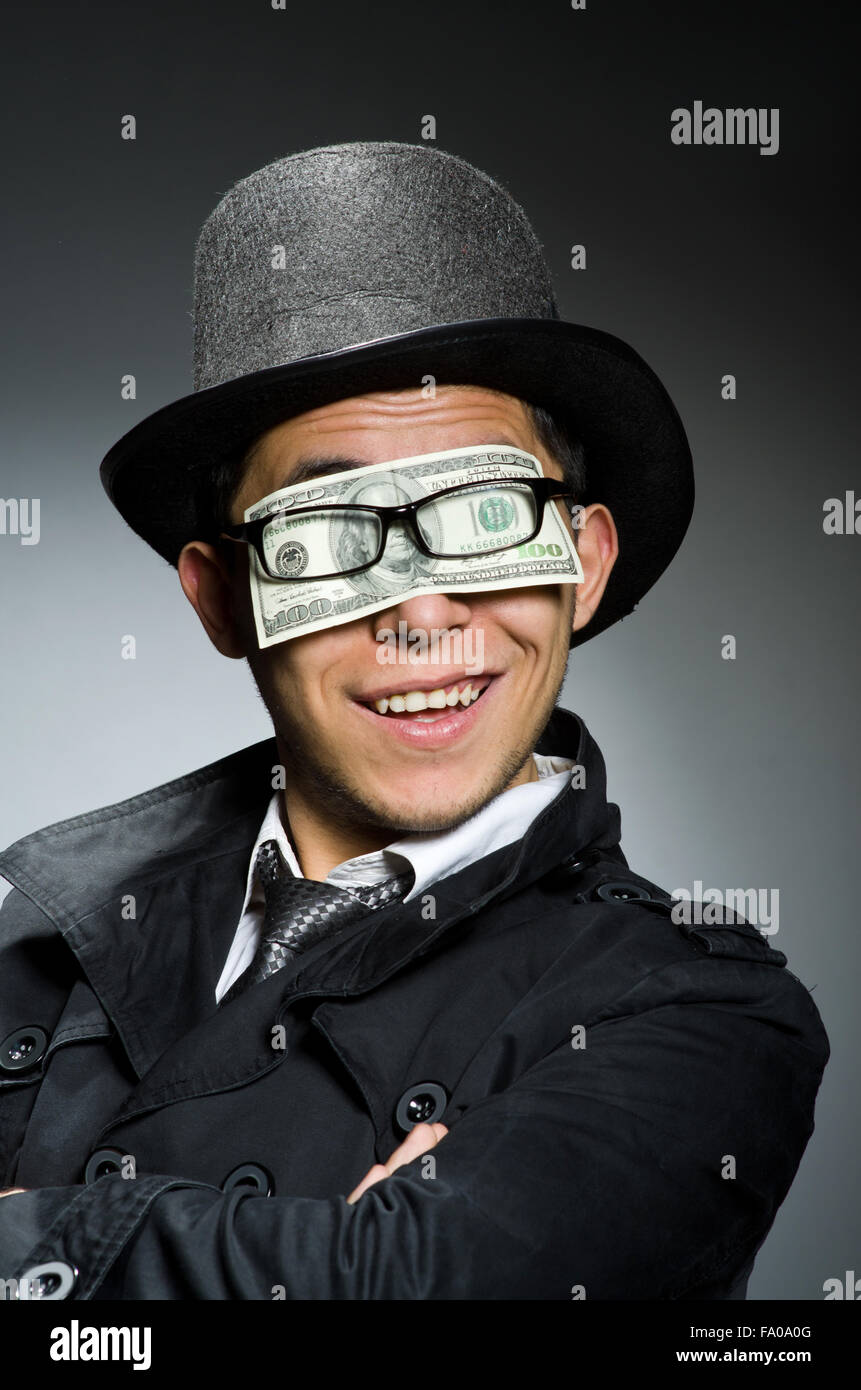 Young man in black coat holding money against gray Stock Photo - Alamy