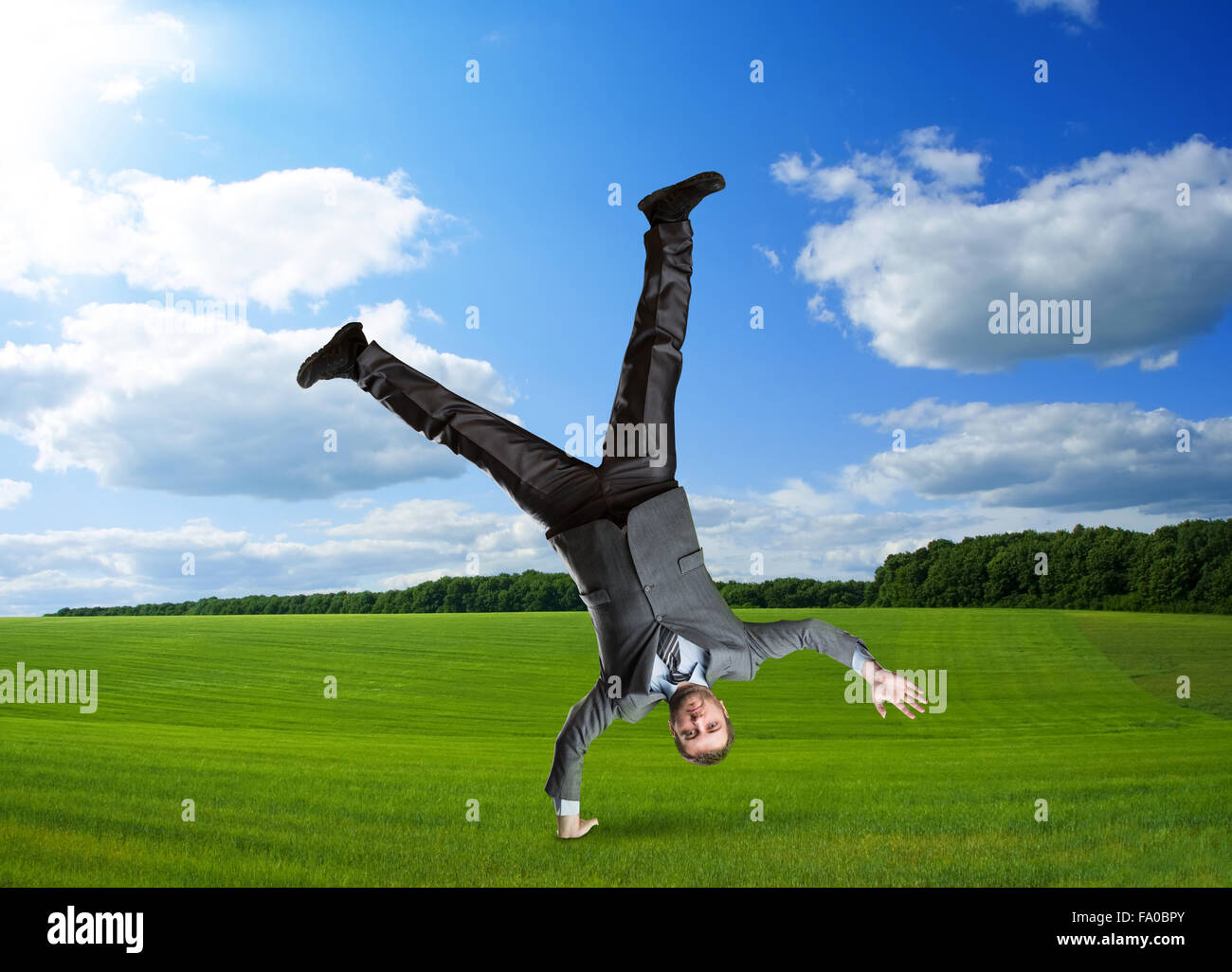 Businessman standing on one hand Stock Photo - Alamy