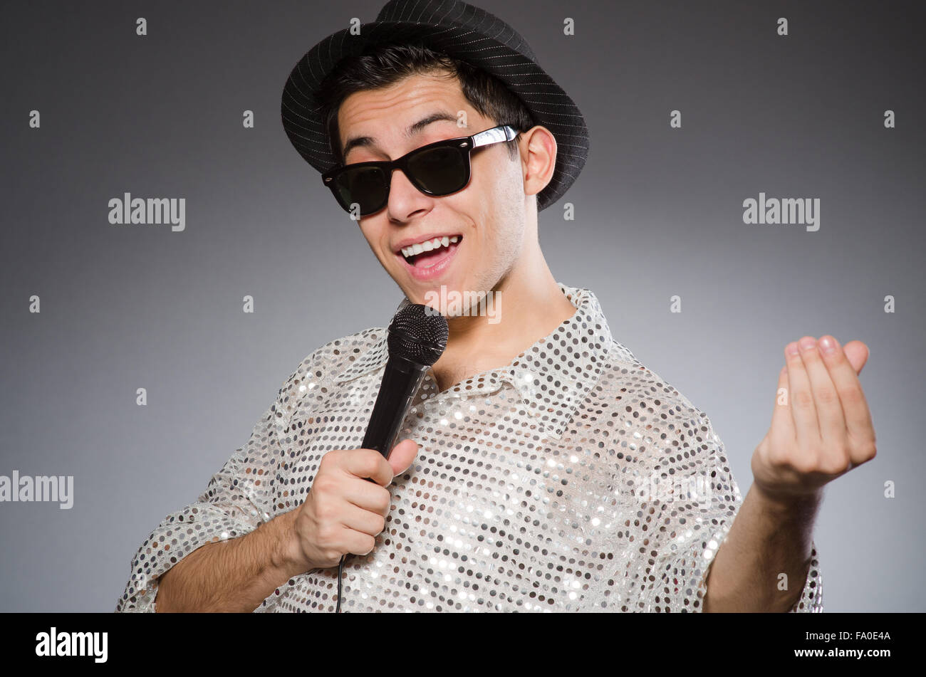 Young cheerful singer with microphone Stock Photo - Alamy