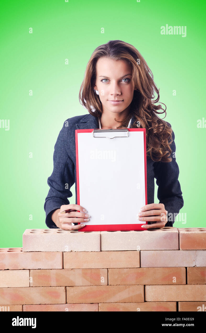 Woman builder and brick wall Stock Photo - Alamy