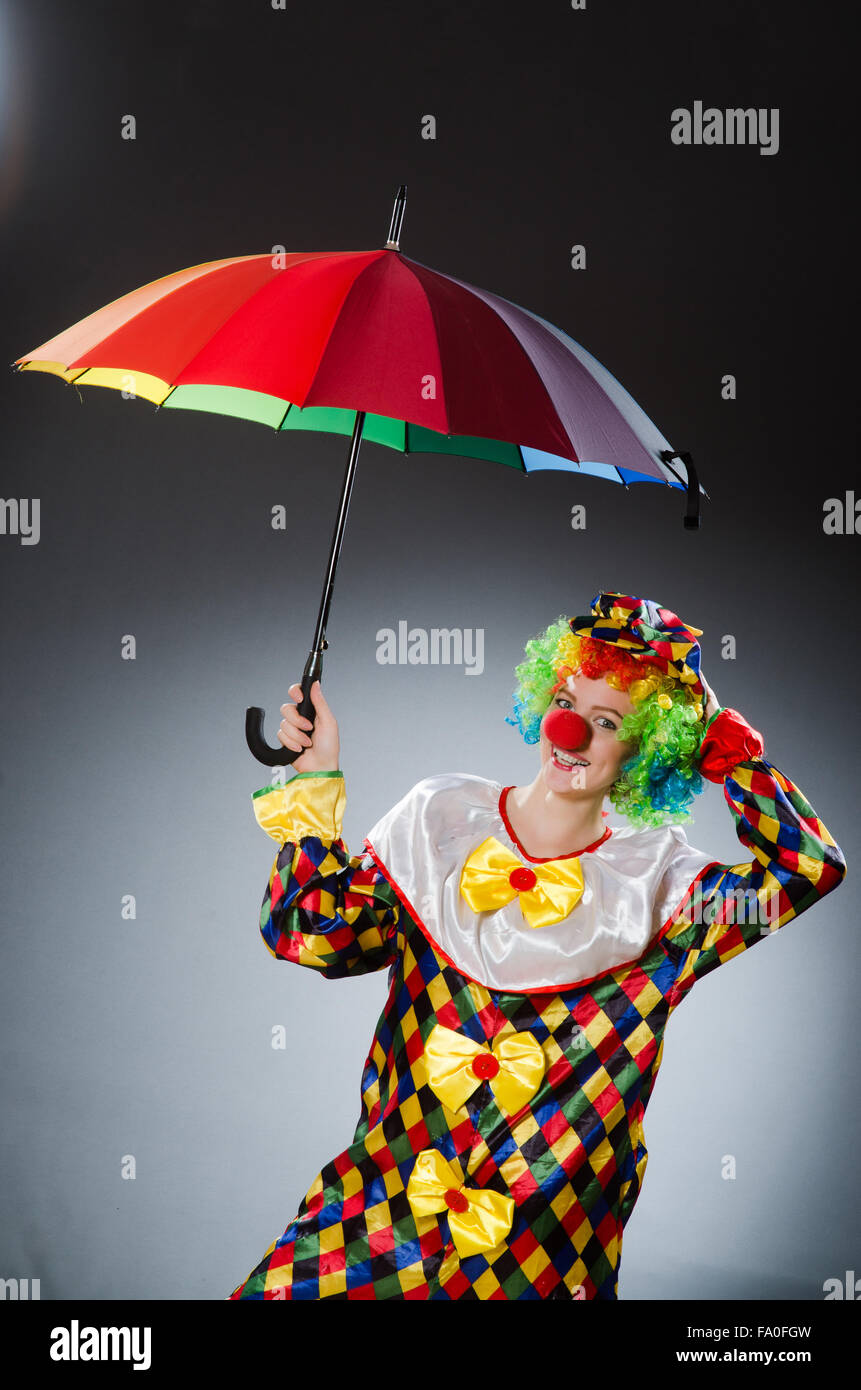 Clown with umbrella in funny concept Stock Photo - Alamy