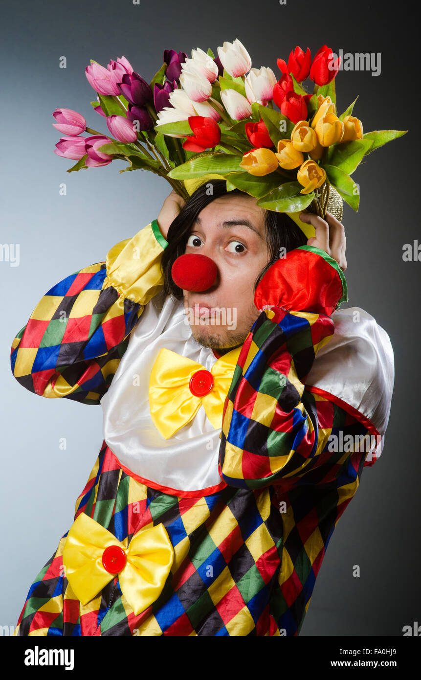 Clown with tulip flowers in funny concept Stock Photo - Alamy